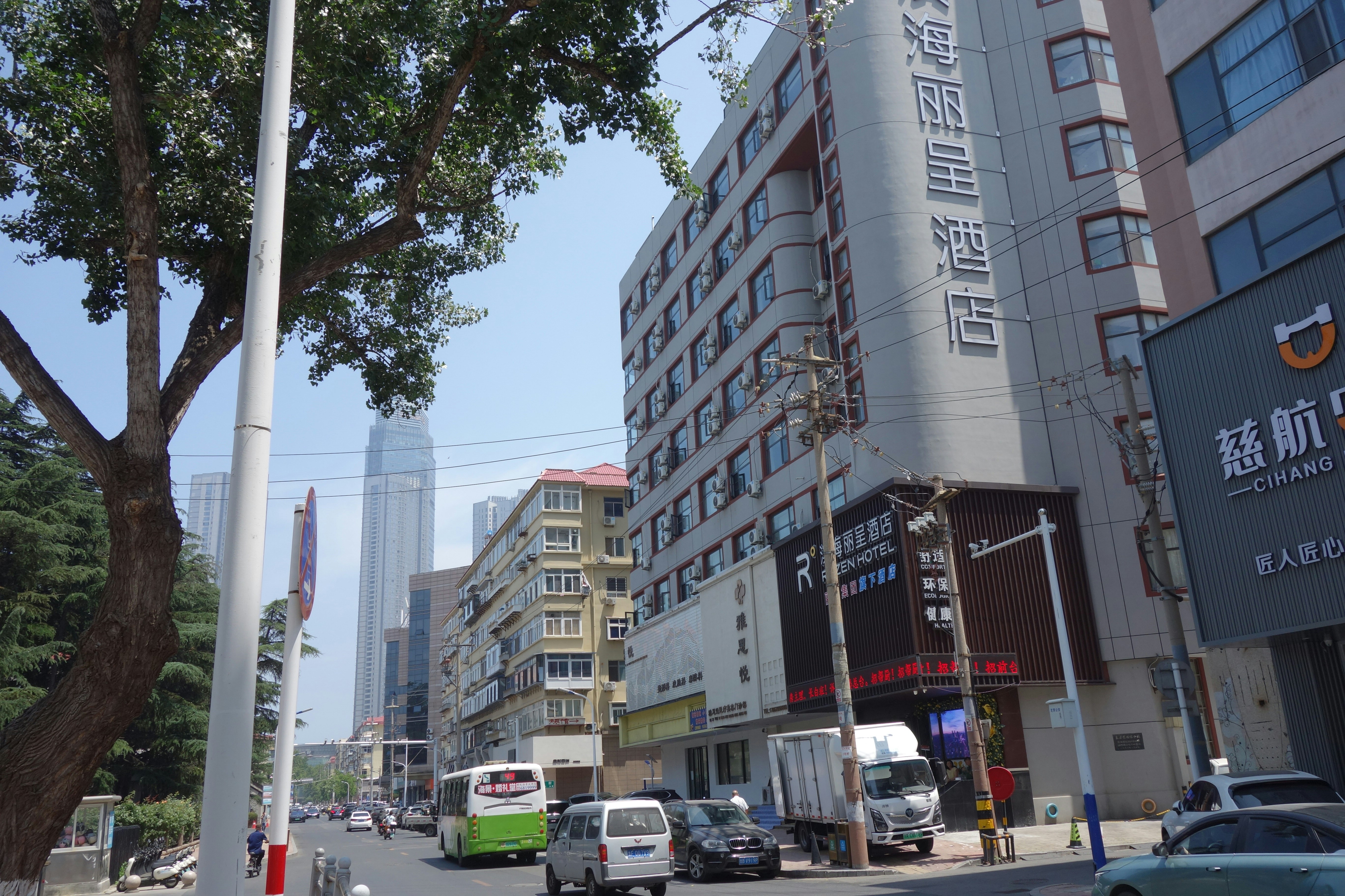 Urban Street Pulse: A City Block Framed by Towers and a Green Bus