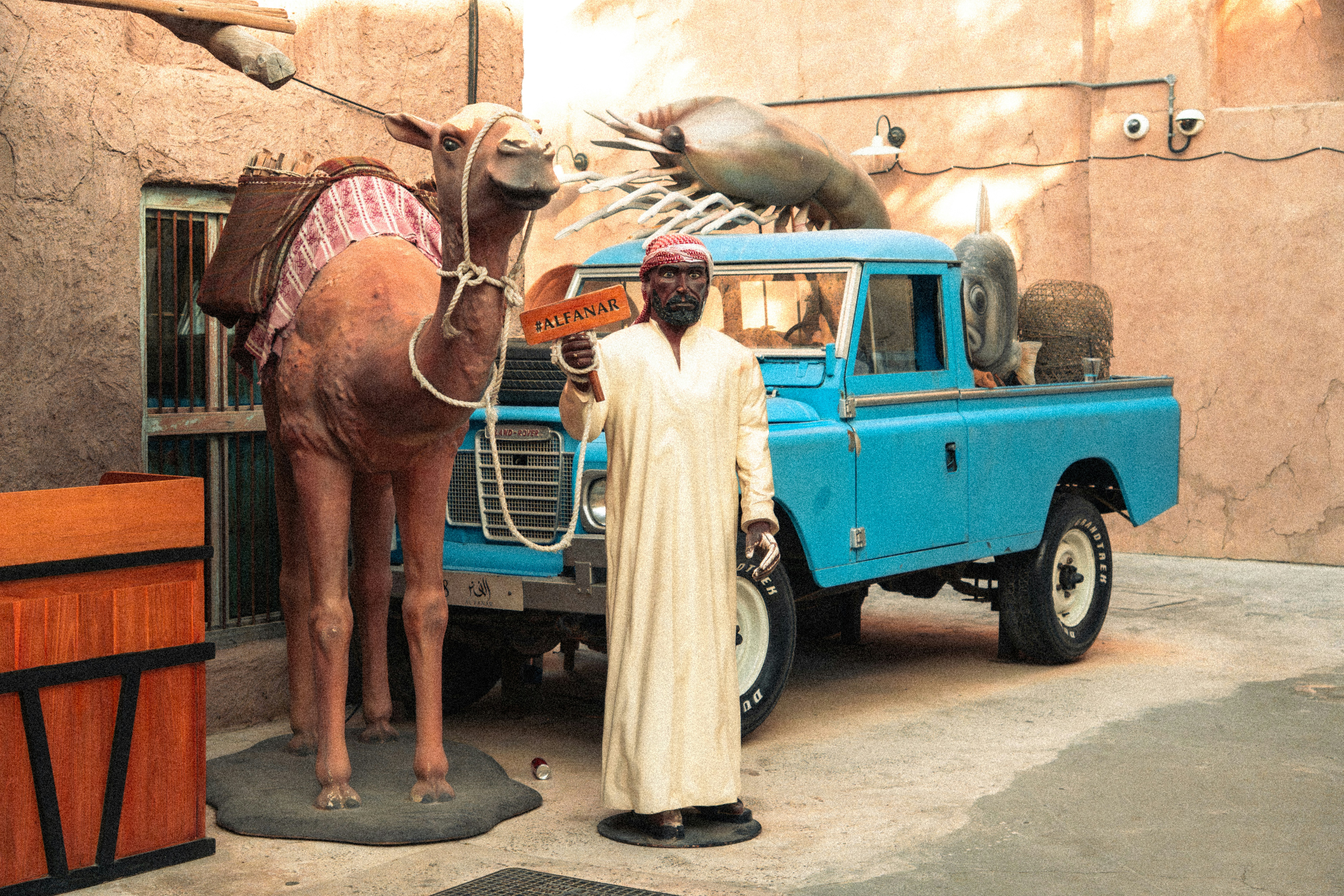Dune Roadside Bazaar: A Man with a Lantern-Book Stance by a Blue Pickup