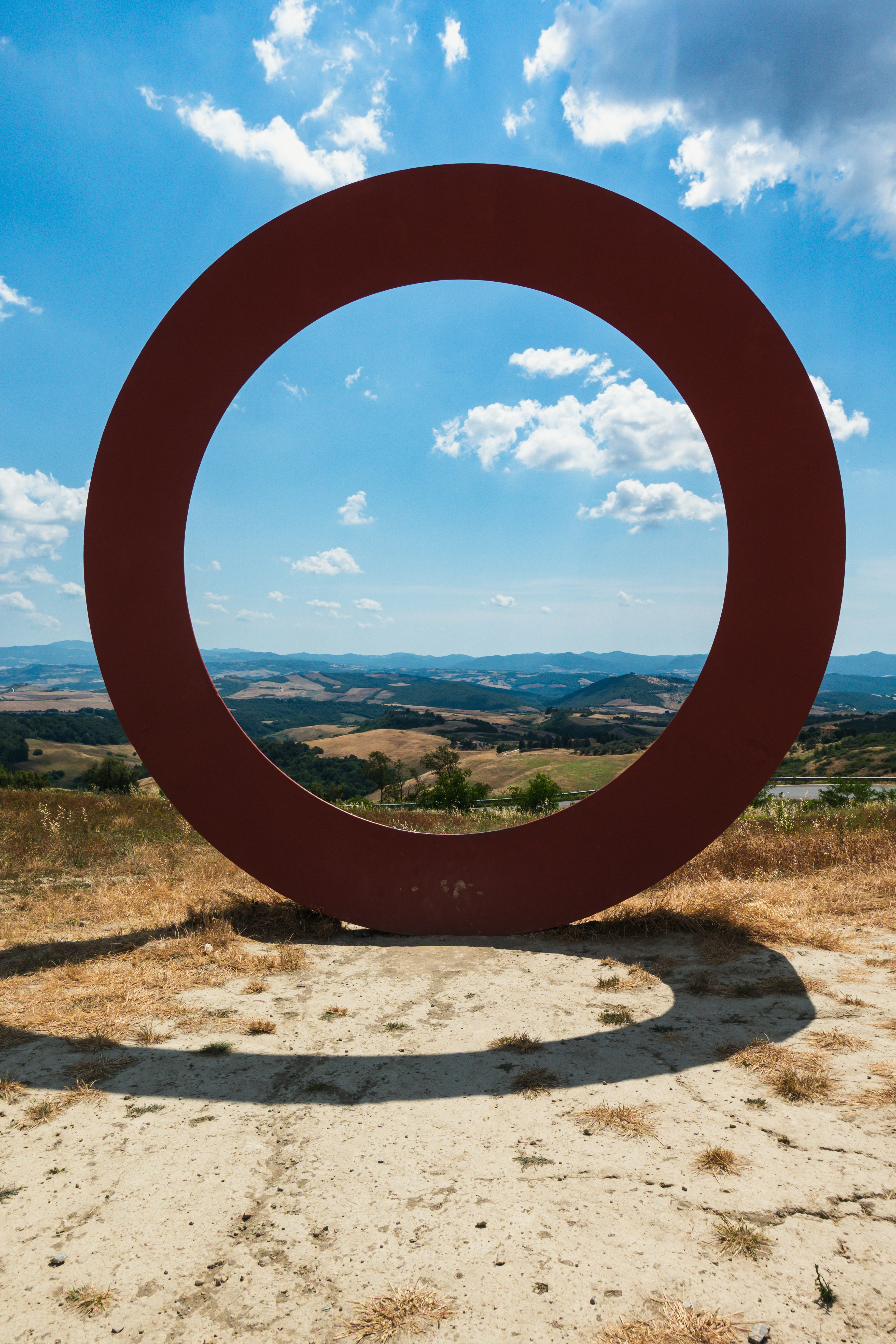 Red Ring, Blue Sky: A Portal Over Rolling Hills