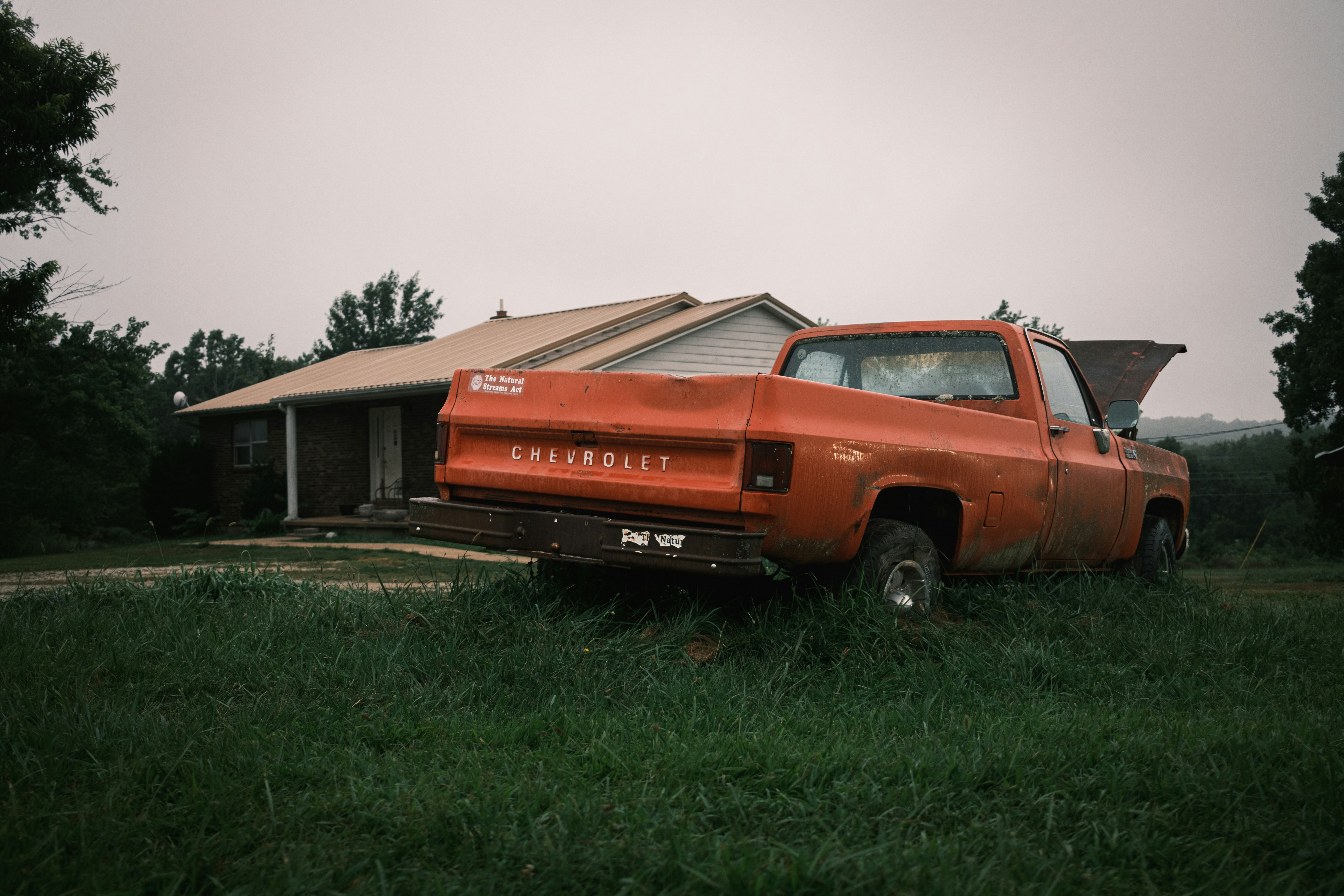 Deserted Cheyenne: A Rusted Relic Watches Over a Quiet Farm