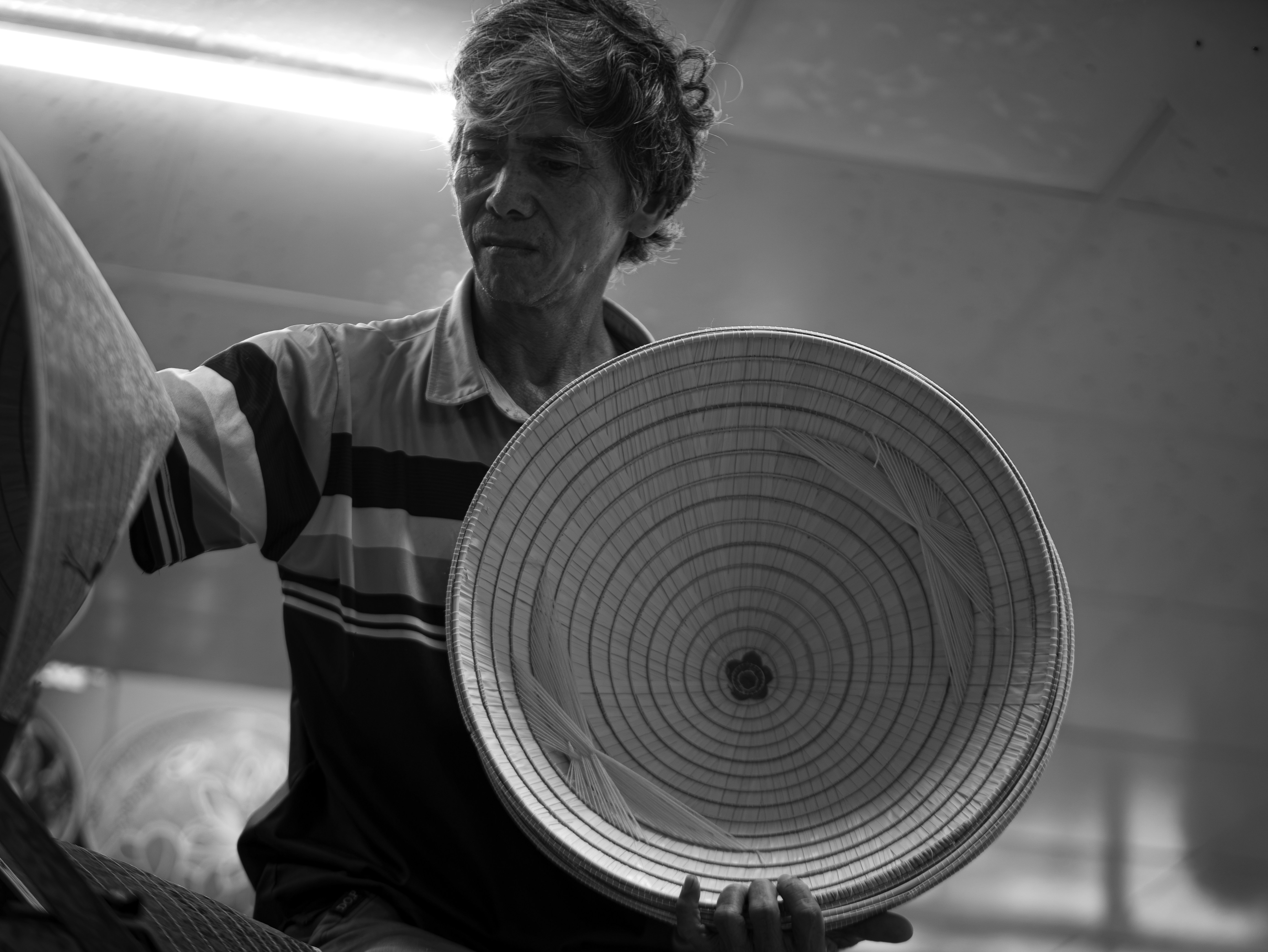 Cone of Focus: A Worker’s Gaze Beneath the Weave of a Straw Basket