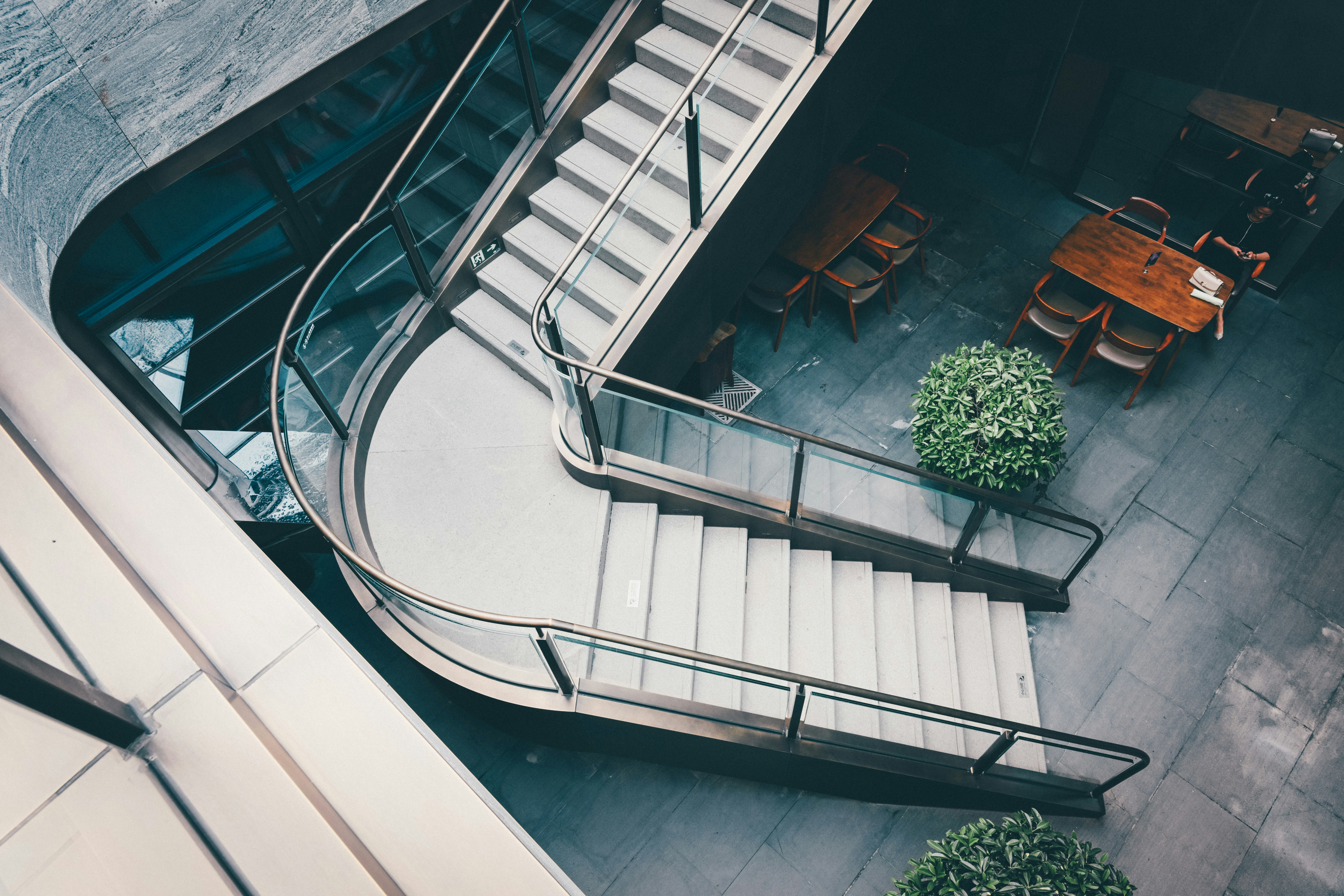 Aerial Staircase Circuit: Modern Atrium with Circular Railing and Dining Nook