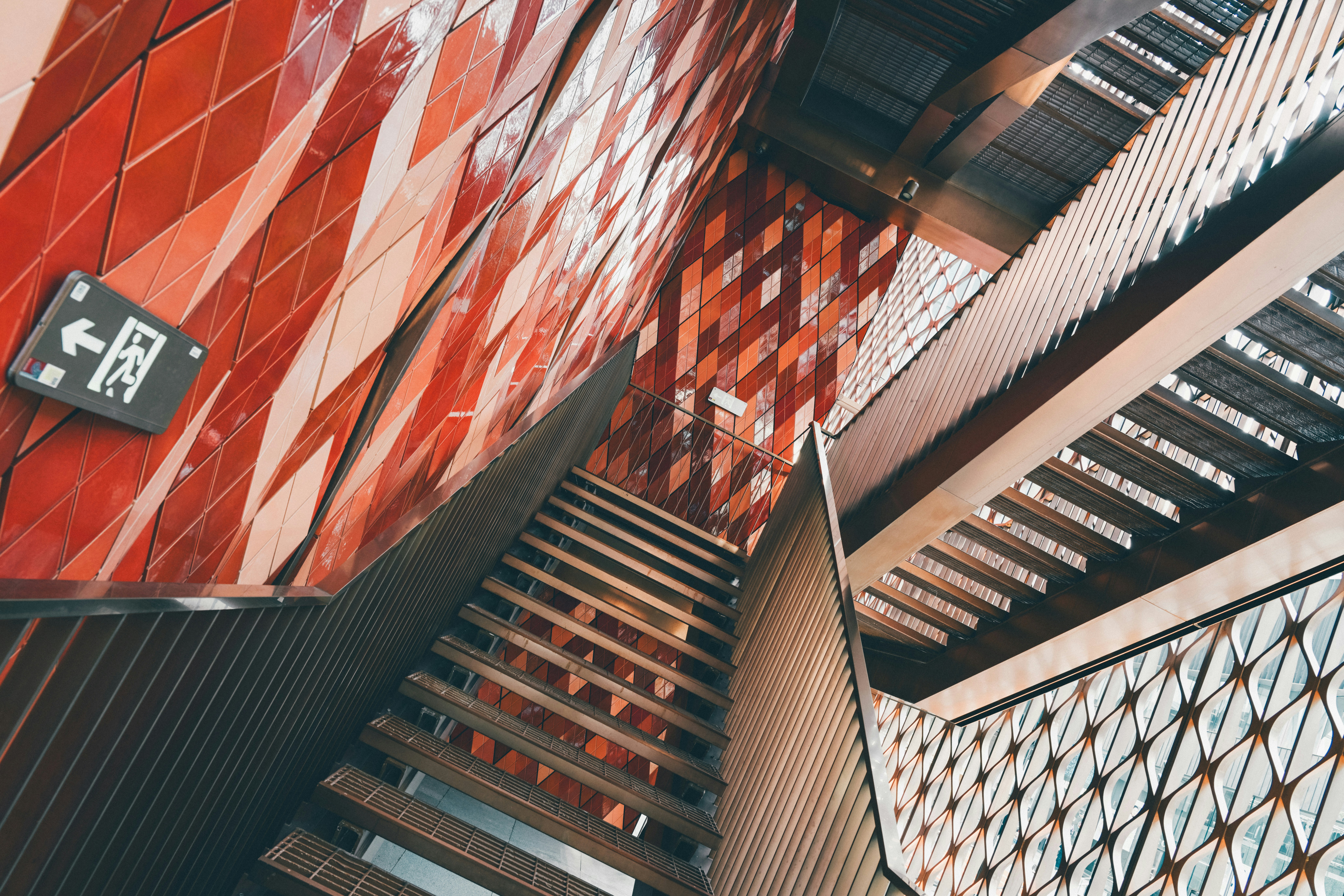 Tilted ascent: geometric pillars and red lattice guiding the eye upward