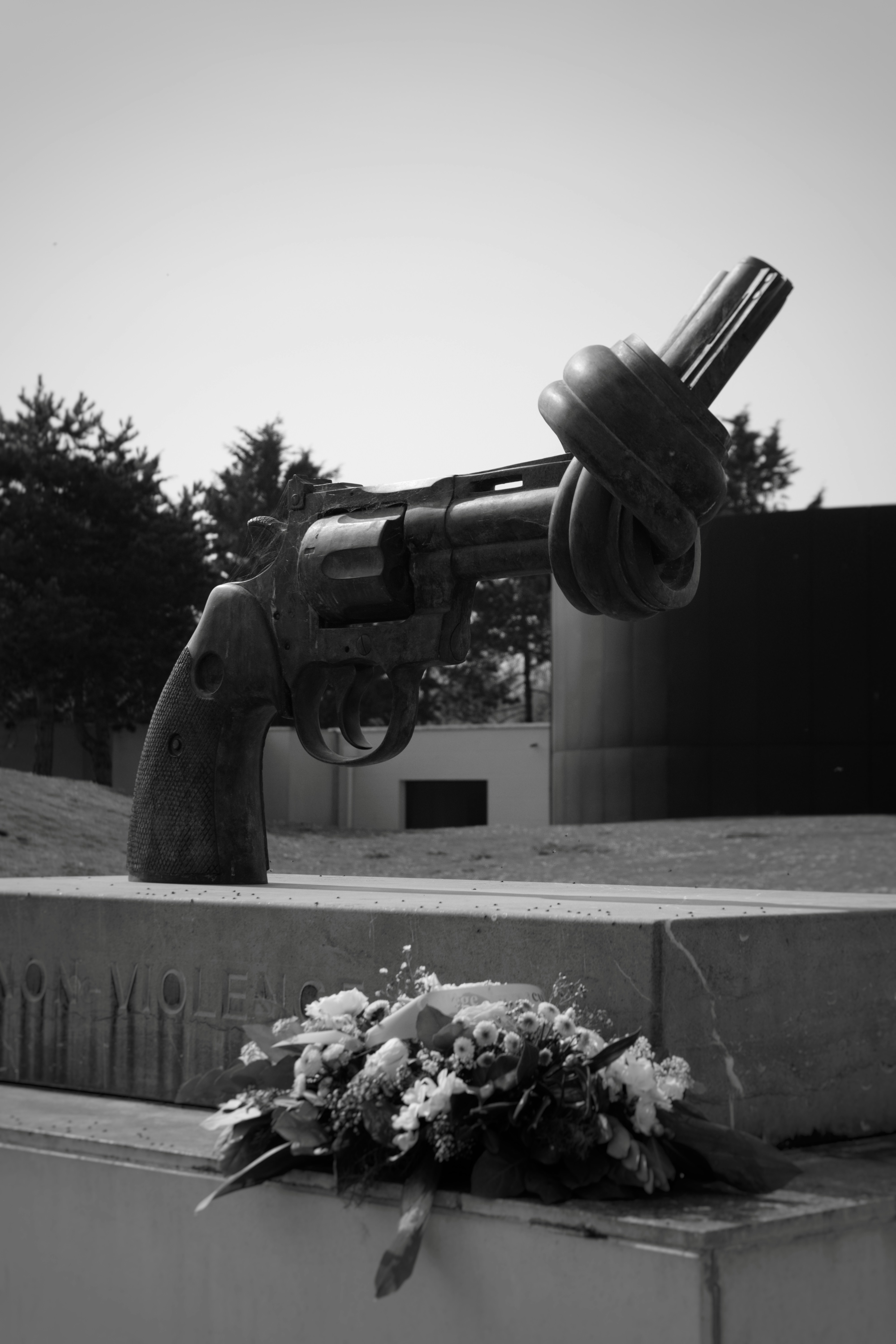 Silenced Memory: A Gun Monument with Flowers at Rest
