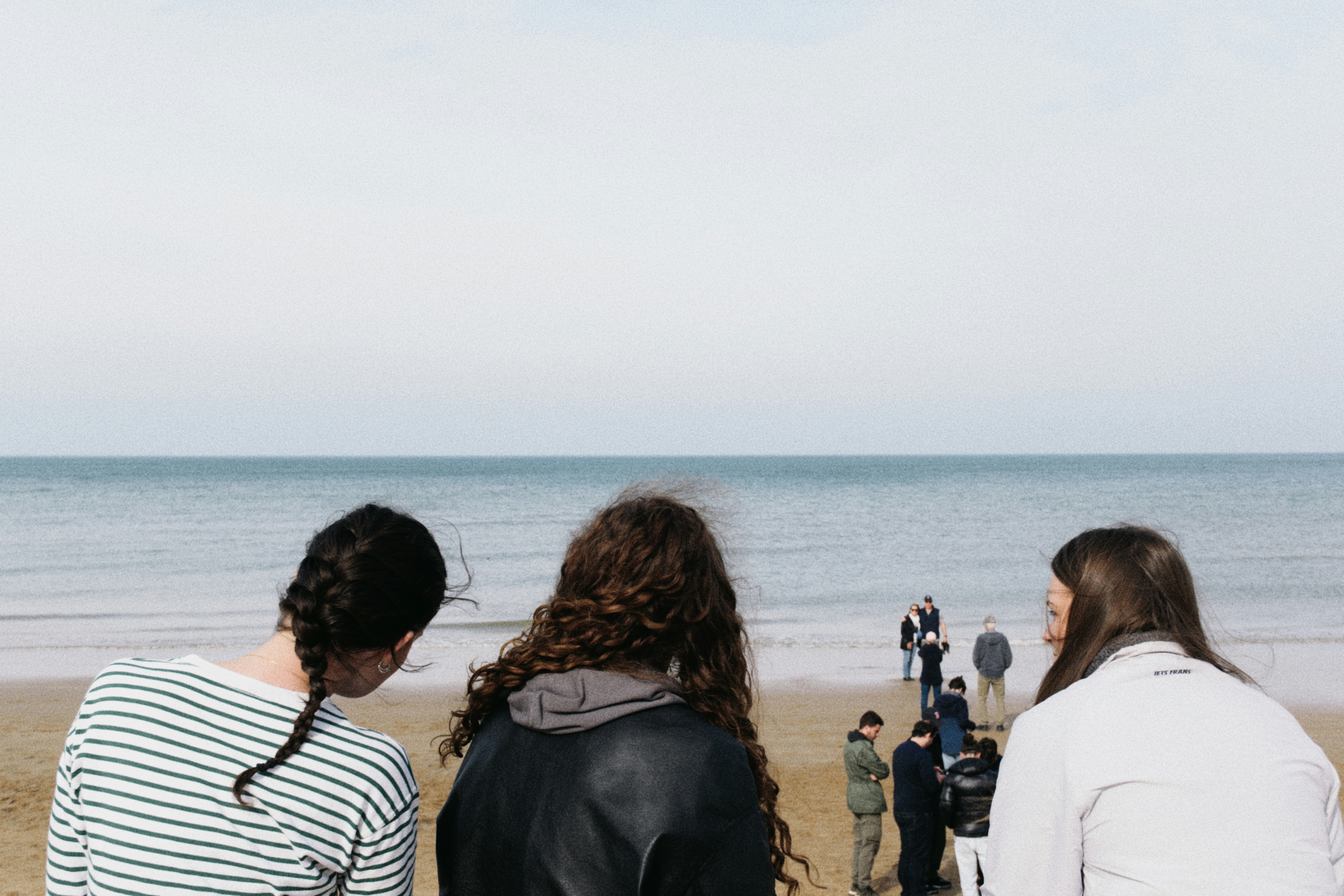 Beachside Assembly: Friends Gazing Toward a Distant Group
