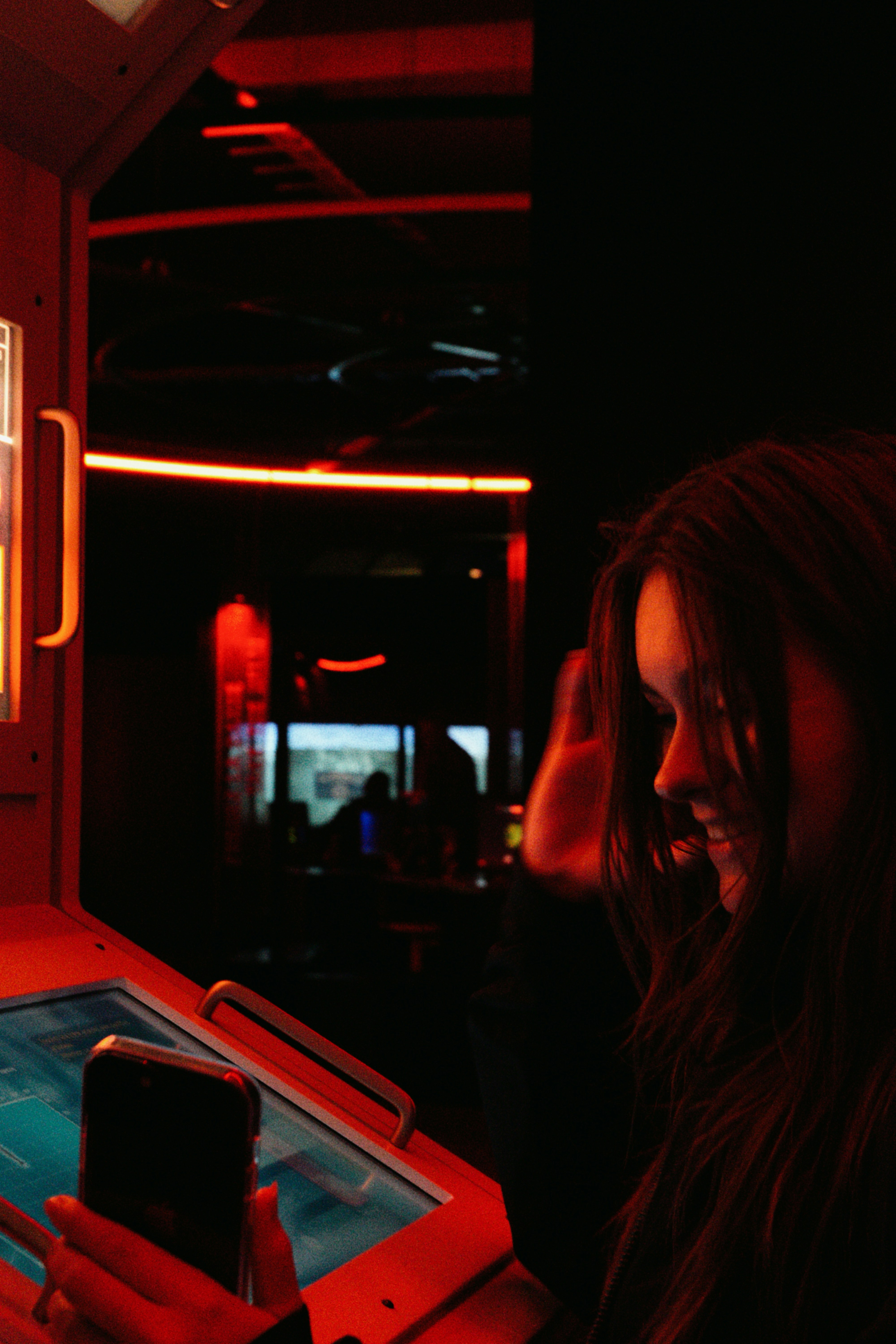 Neon-lit kiosk portrait with a contemplative rider