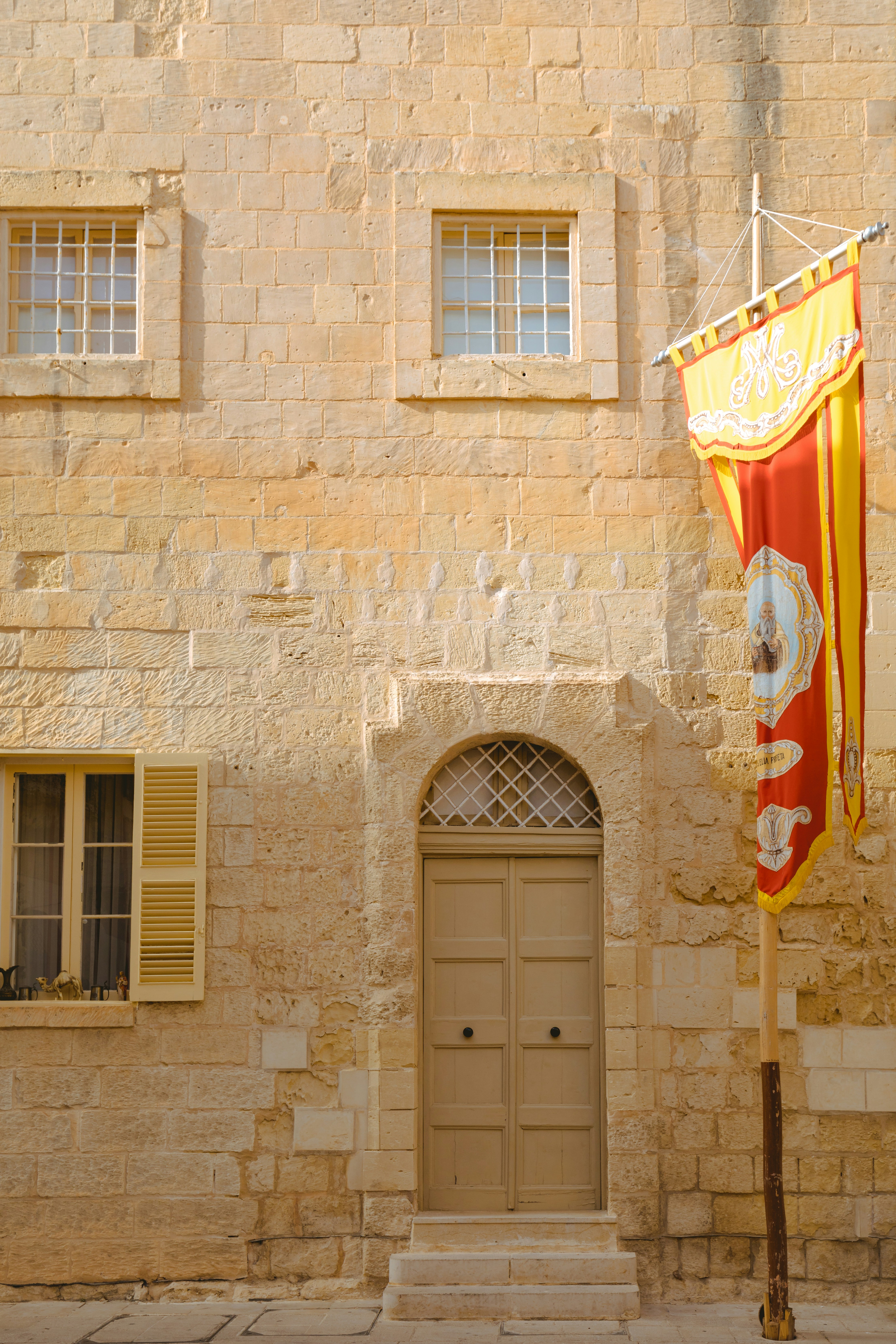 Golden Facade and Banner: A Sunlit Stone Archway
