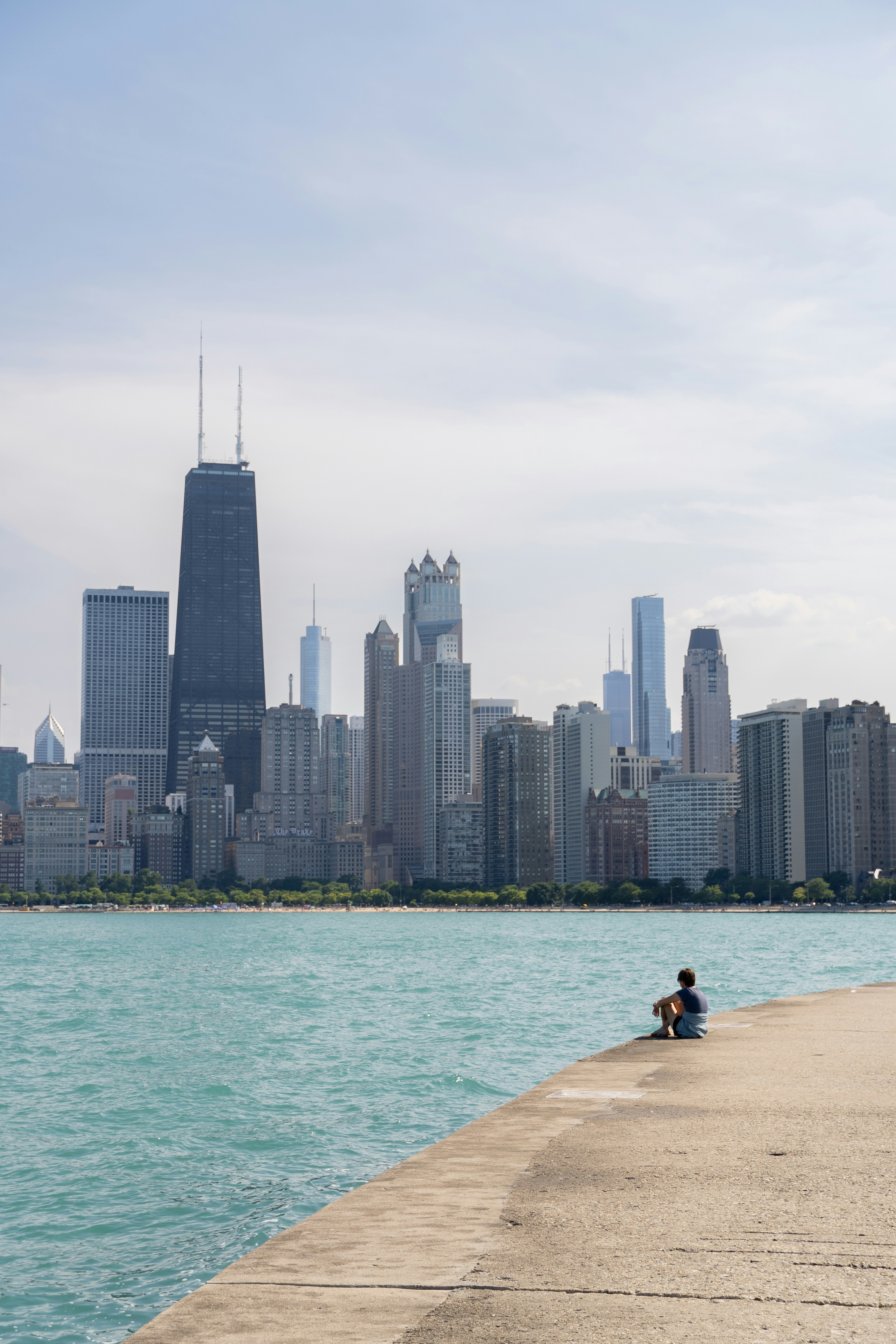 Riverside Silhouette: A Lone Visitor Gazes Toward the Windy City Skyline