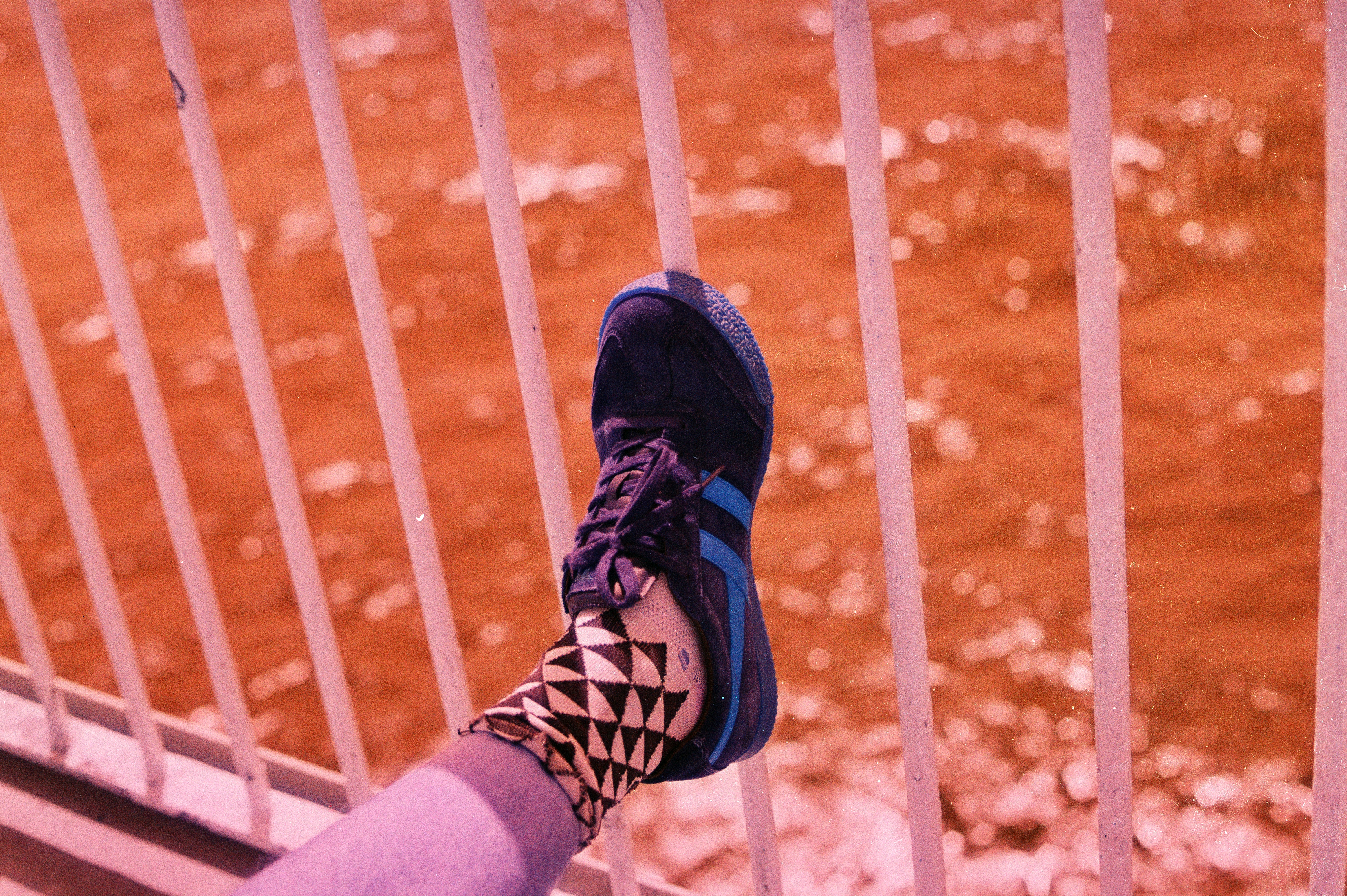 Foot on a railing: a casual escape over a river