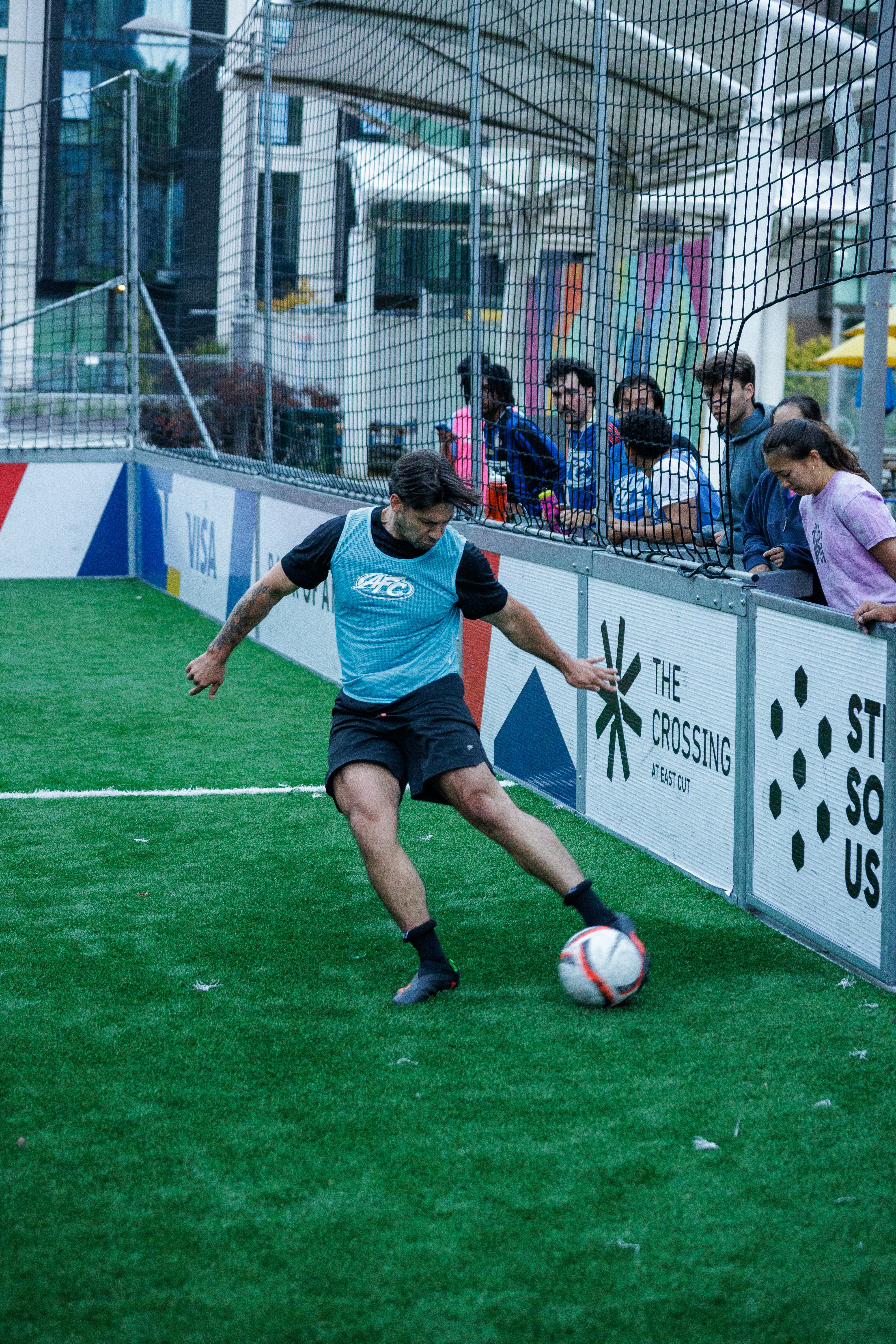 Midfield Moment: A Player Controls the Ball Along the Barrier