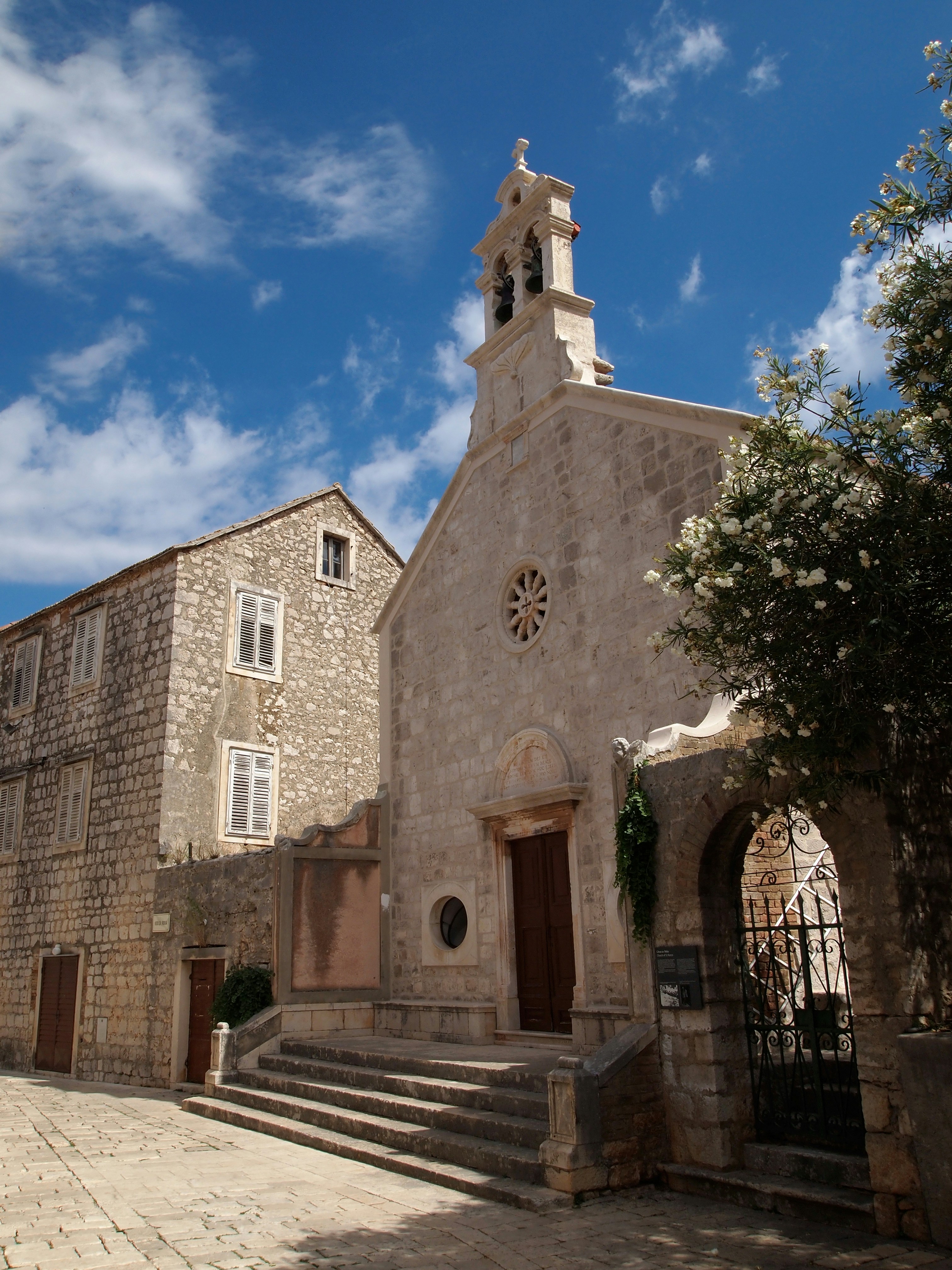 Stone Chapel with Tower Amid Sunlit Courtyard