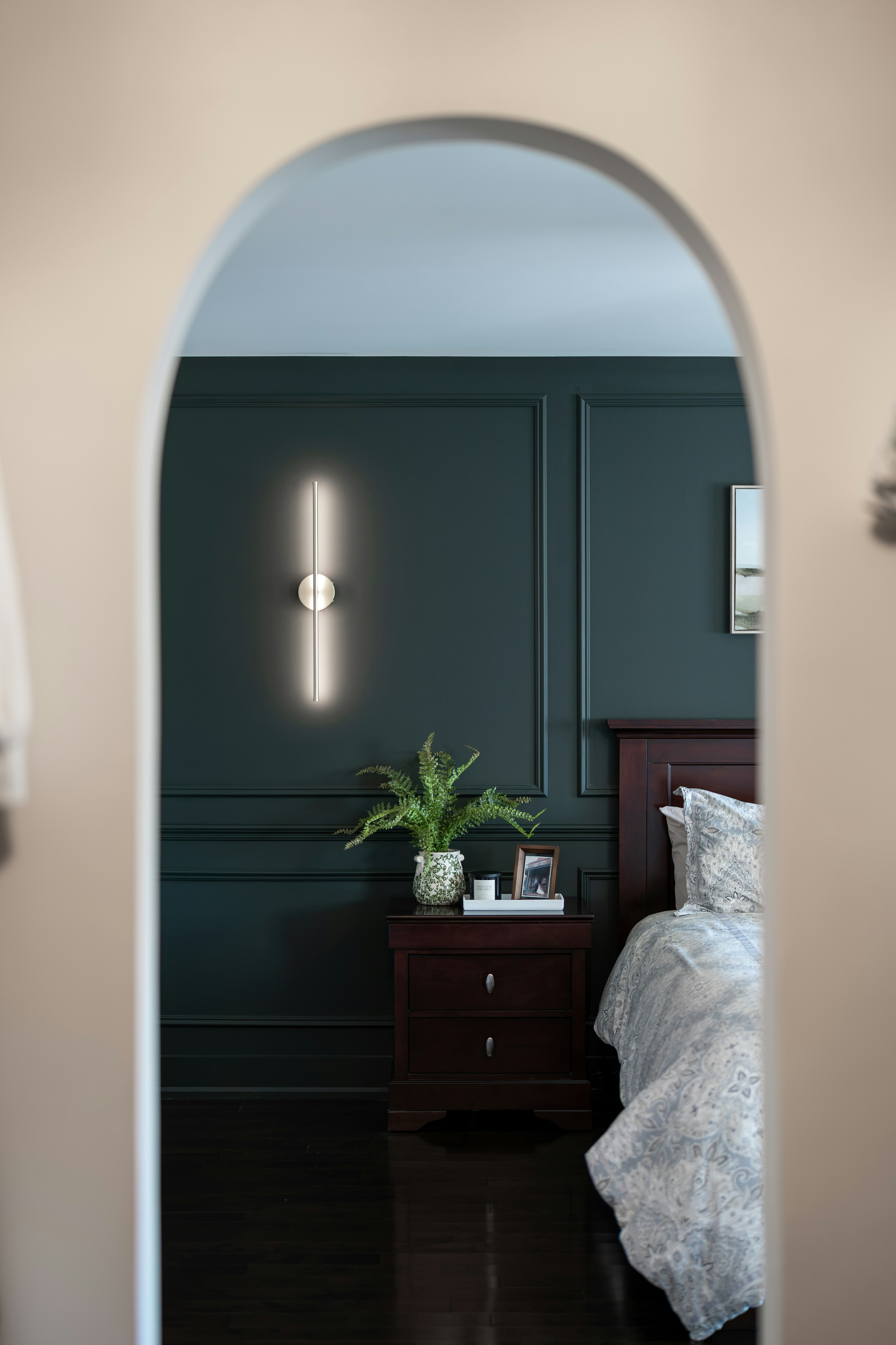 Archway to Tranquility: A Dark-Wreen Bedroom Framed by Soft Light