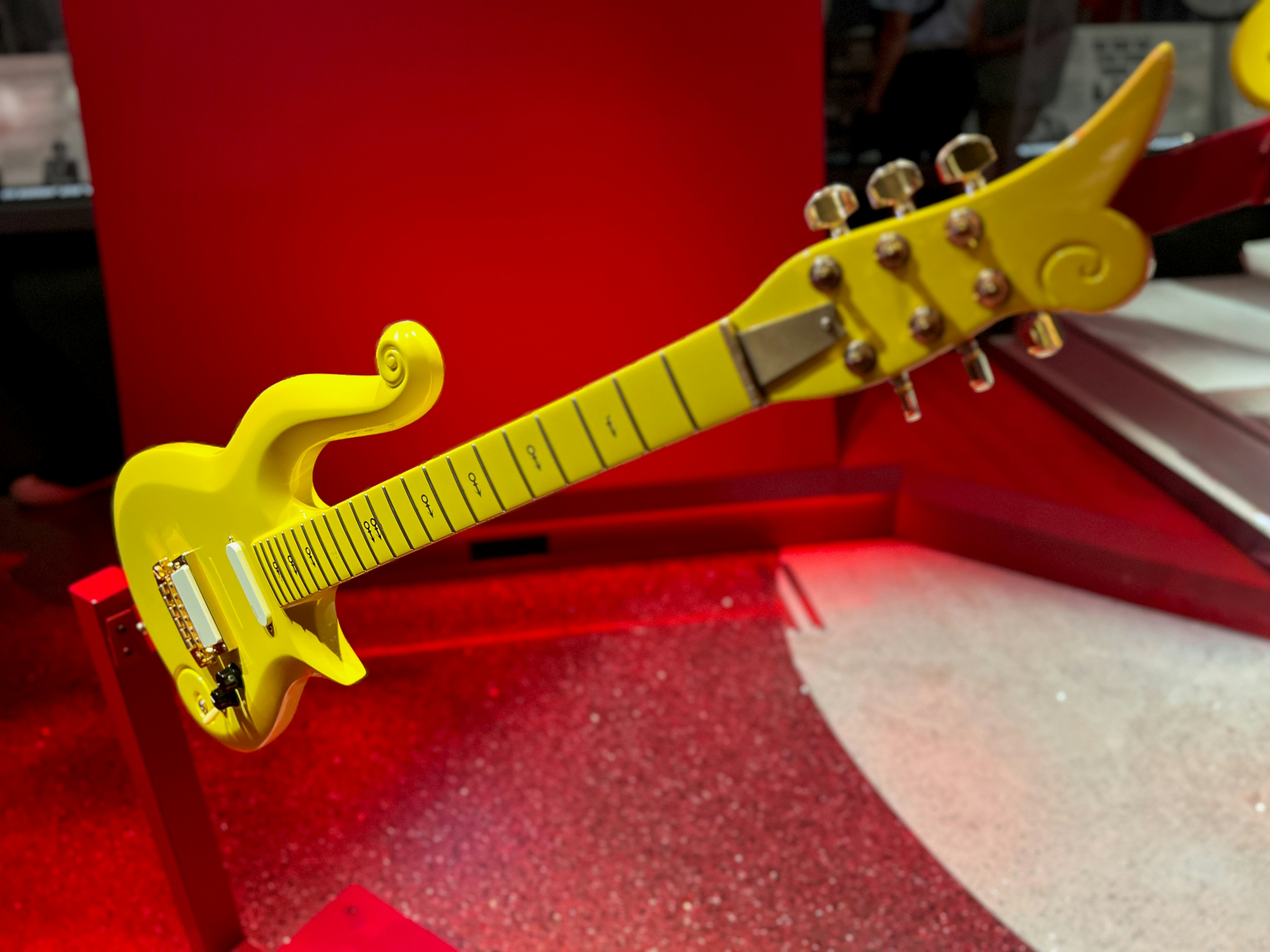 Sunlit Yellow Guitar on a Red Display