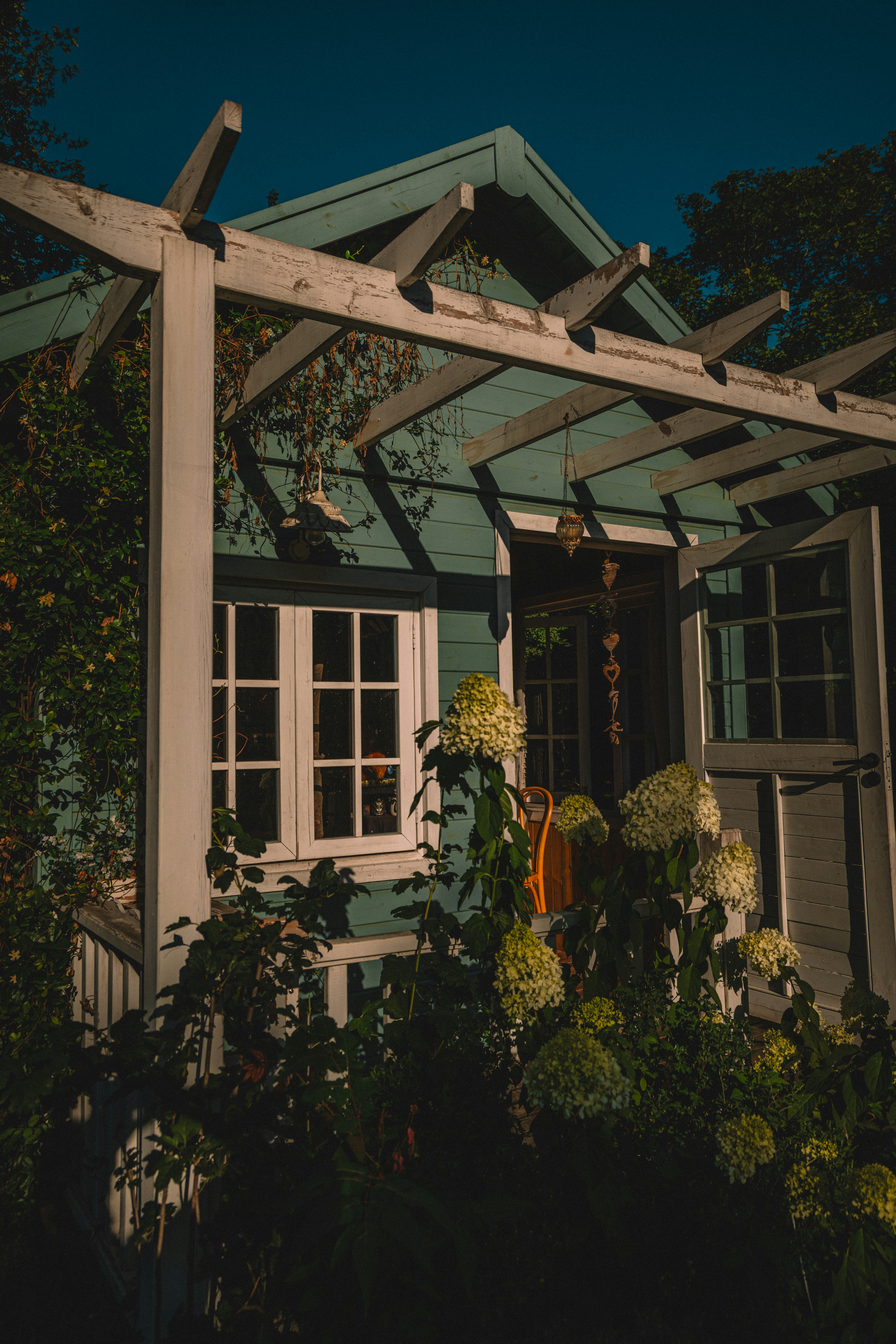 Overgrown Veranda: Light and Leaves on a Teal Cottage