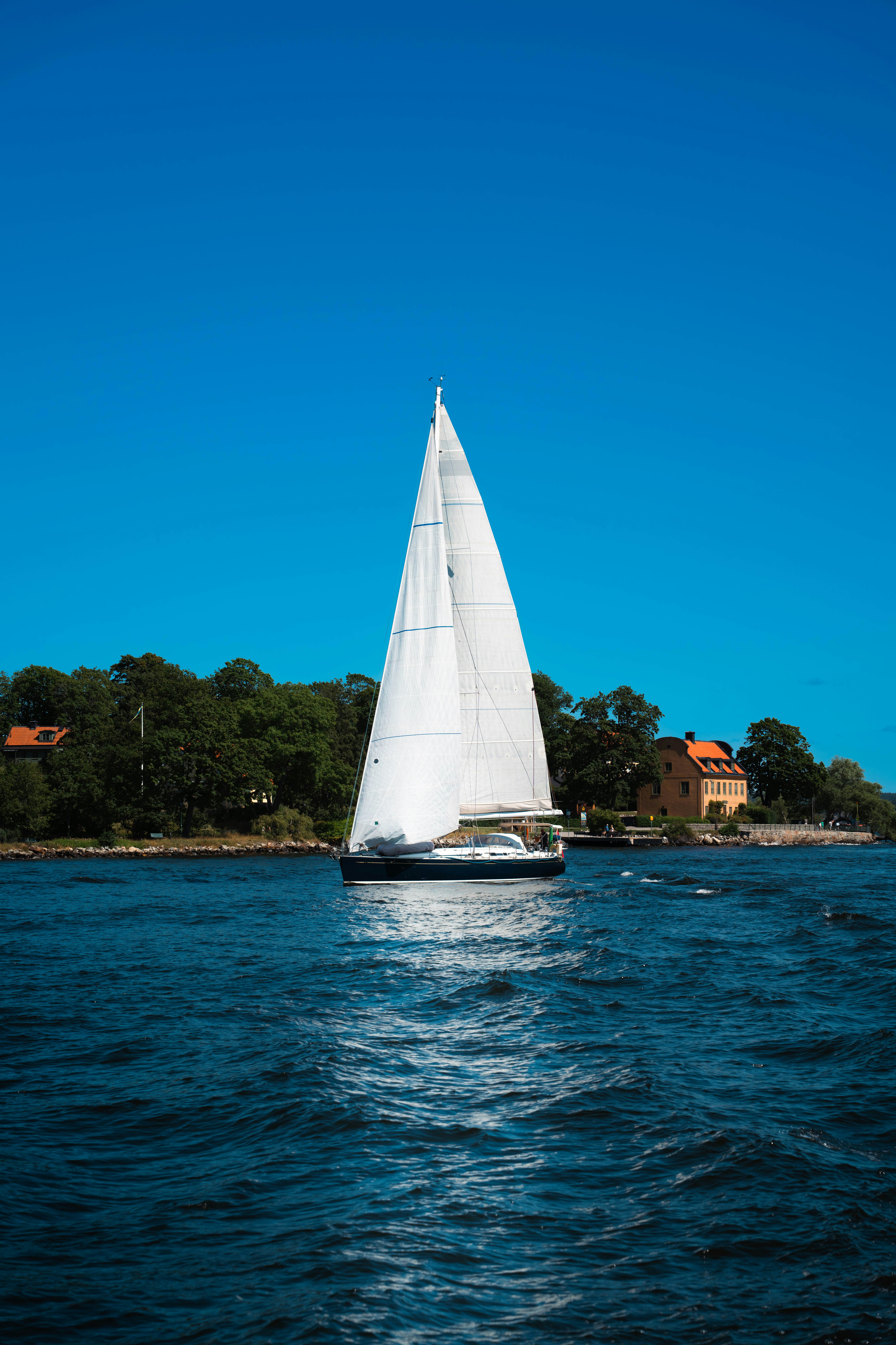 Sailboat on a Quiet Blue Sea under a Clear Sky