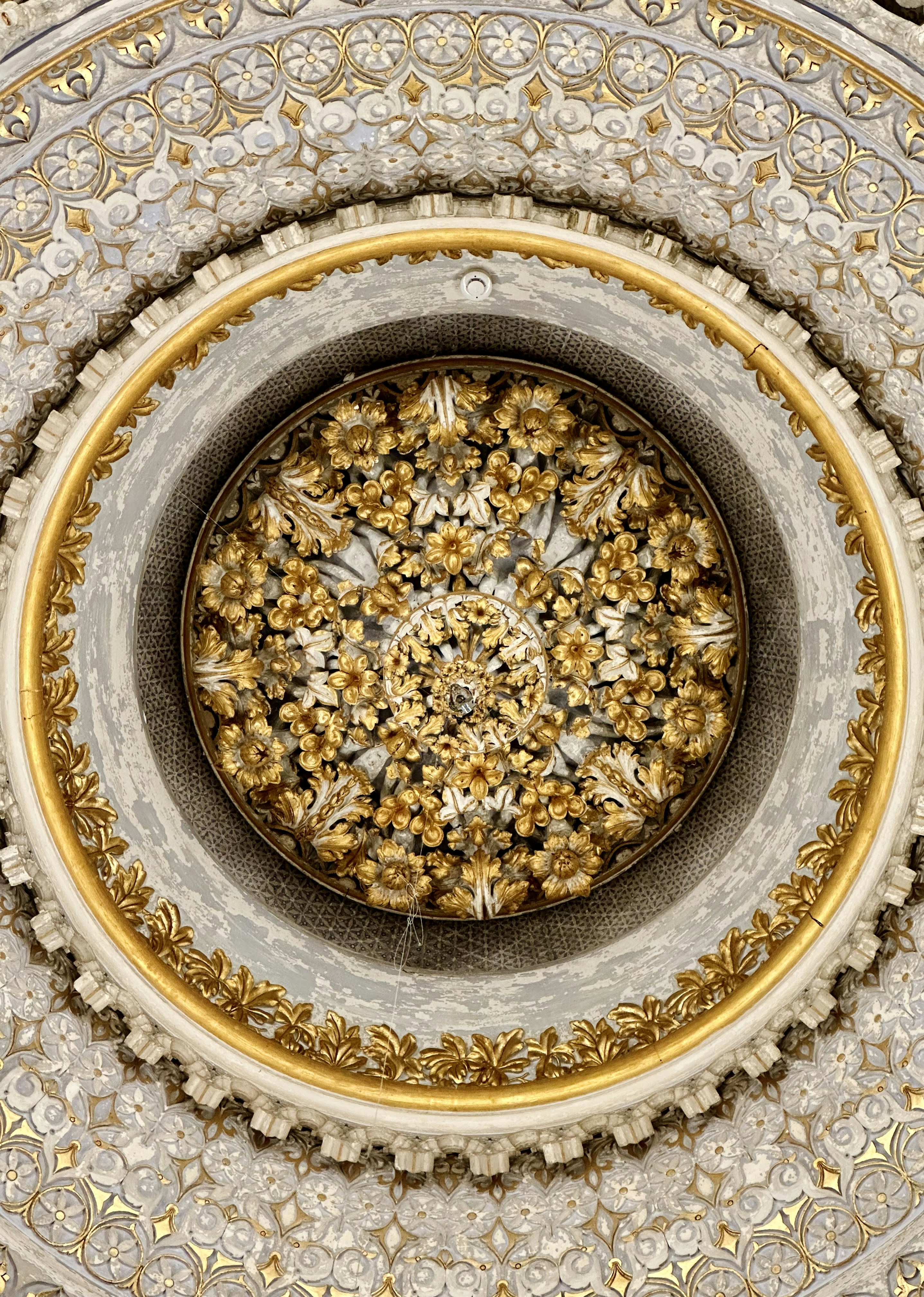 Close-up of a gilded floral medallion on a palace ceiling
