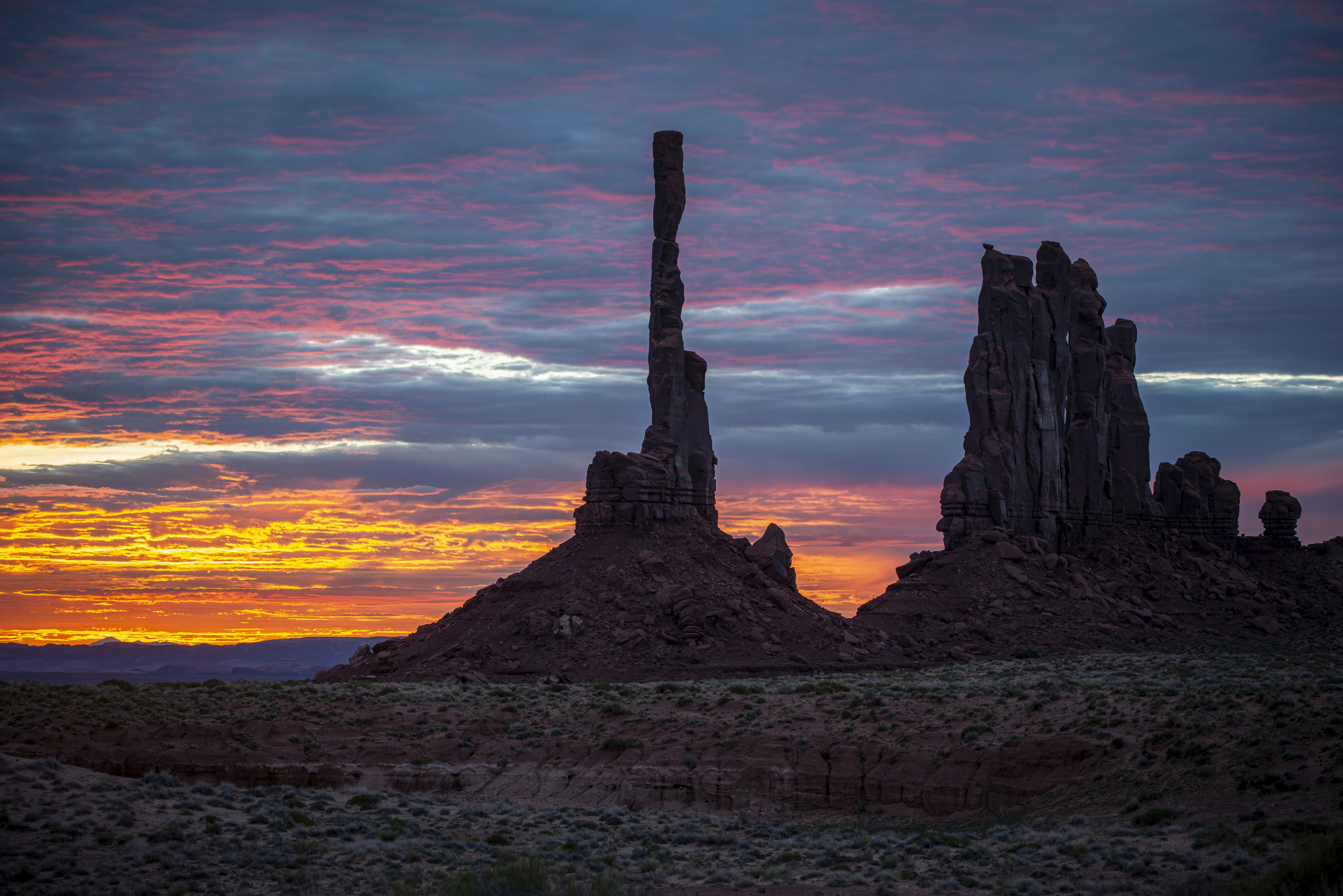 Desert Monoliths at Sunset: Twin Spires Rising from the Red Plain