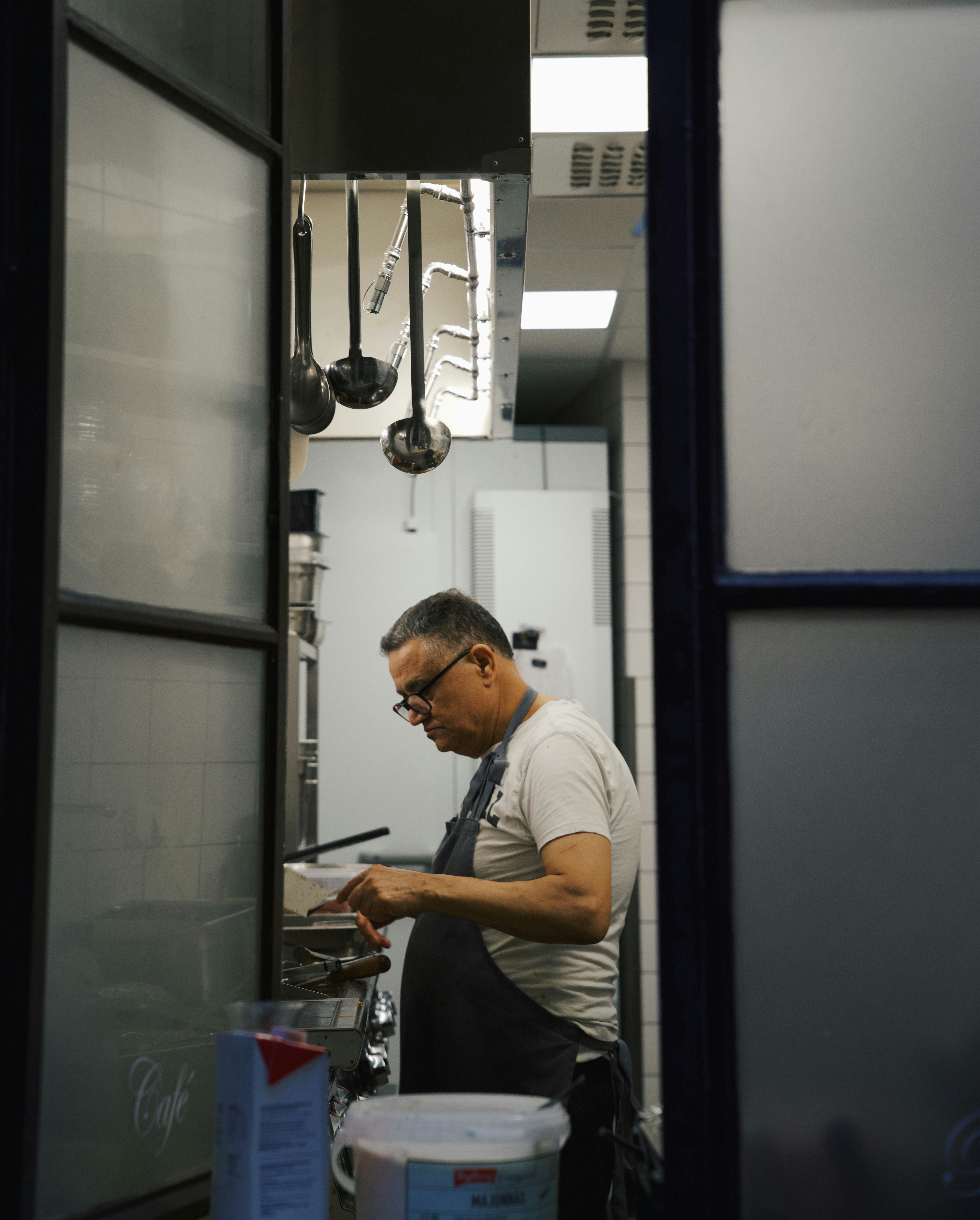 Chef at Work: Quiet Focus in a Narrow Kitchen Corridor