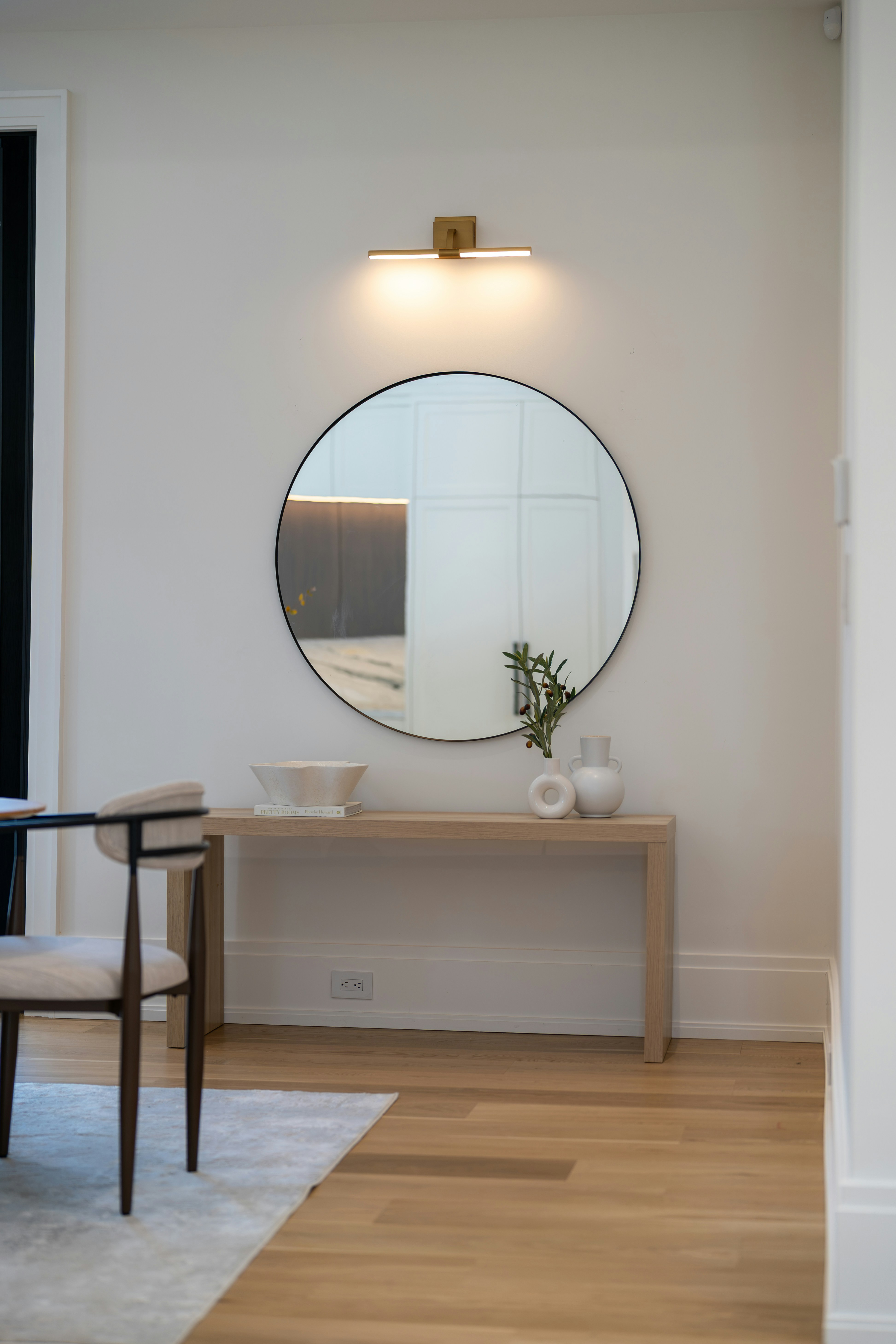 Circular Echo: A Round Mirror Anchored by Minimalist Decor