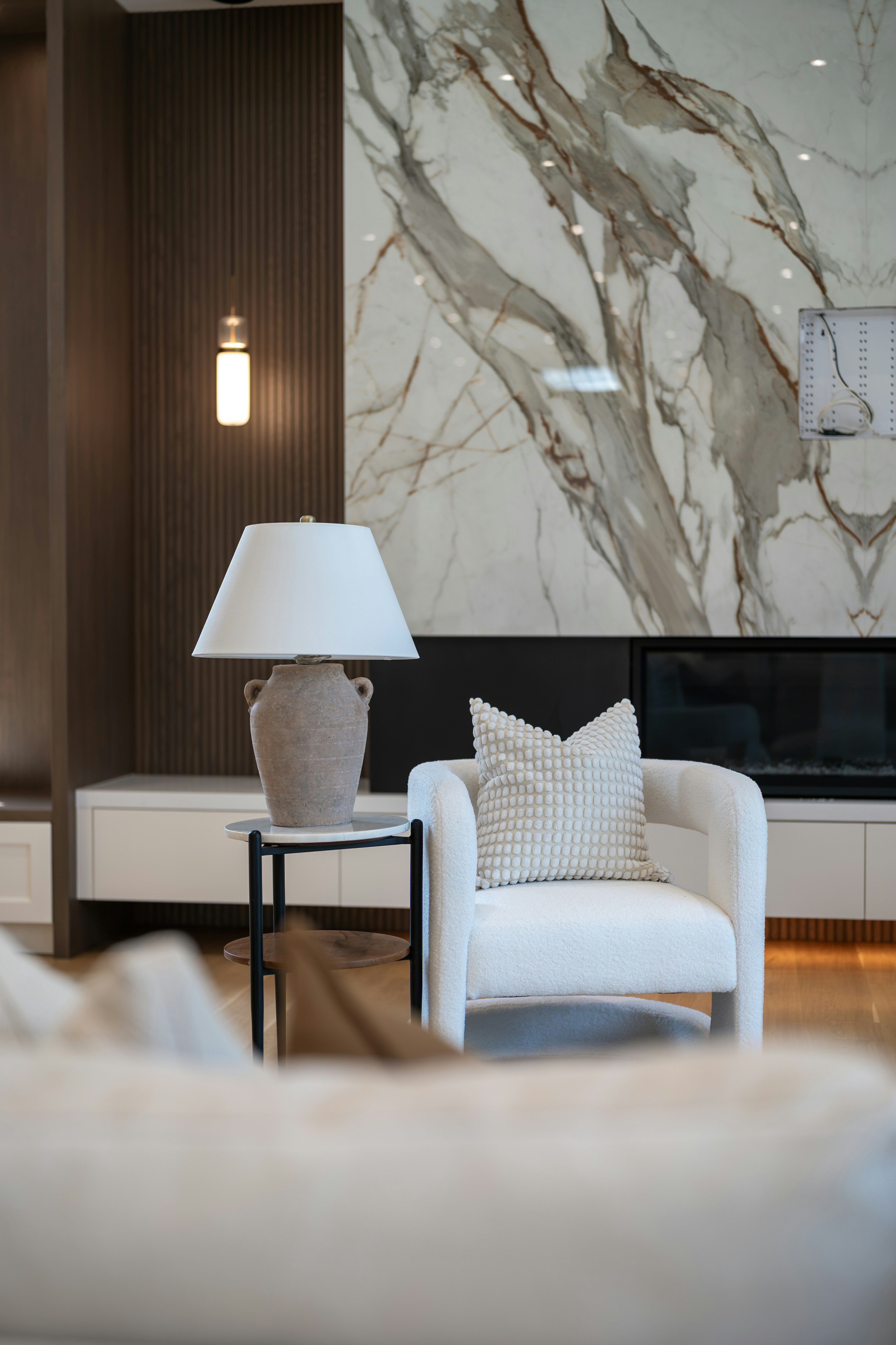 Soft Centerpiece: A Quiet Living Room with a Sculpted Lamp and Marble Mantel