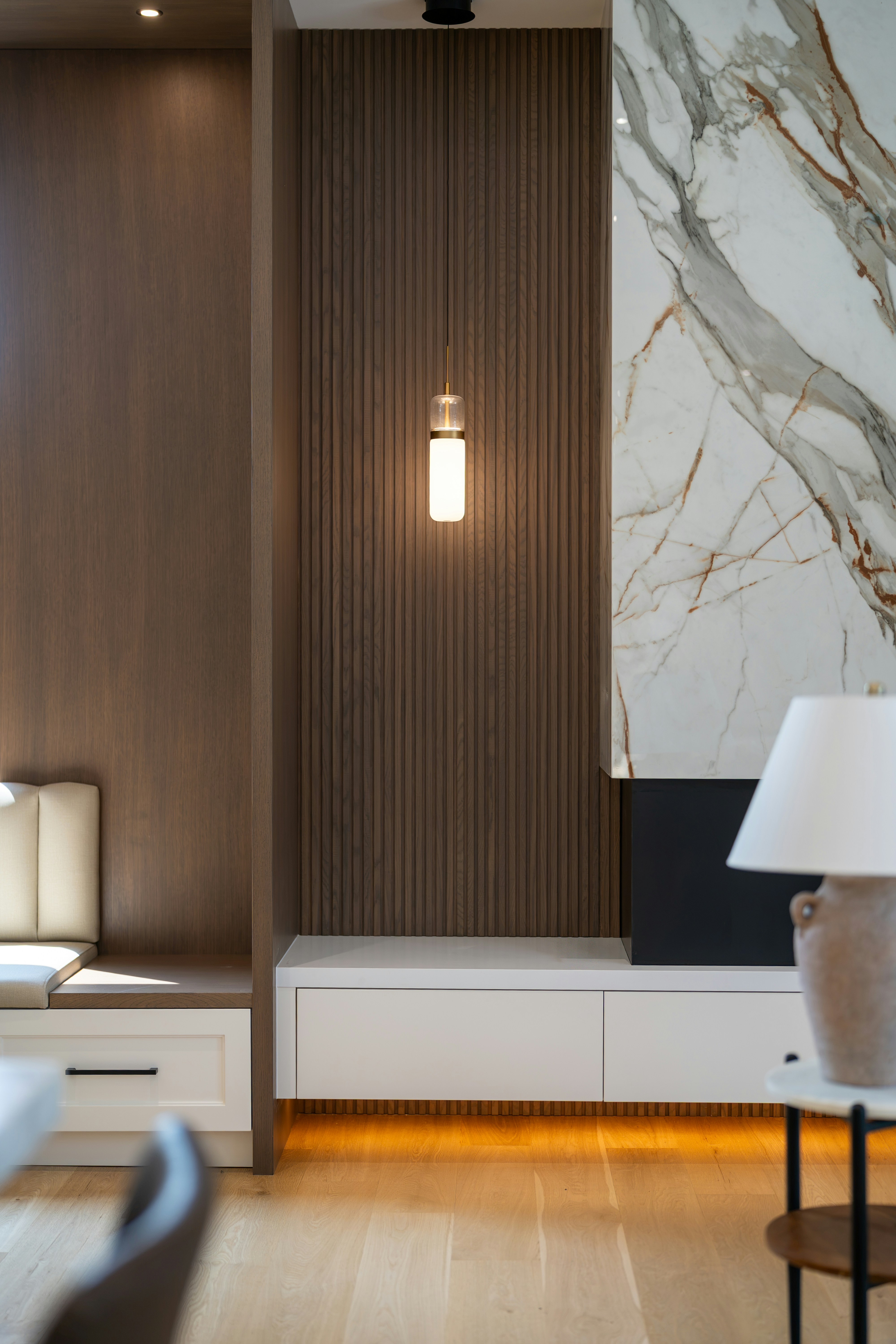 Warm Minimalism: Vertical Lantern Framed by Marble and Wood