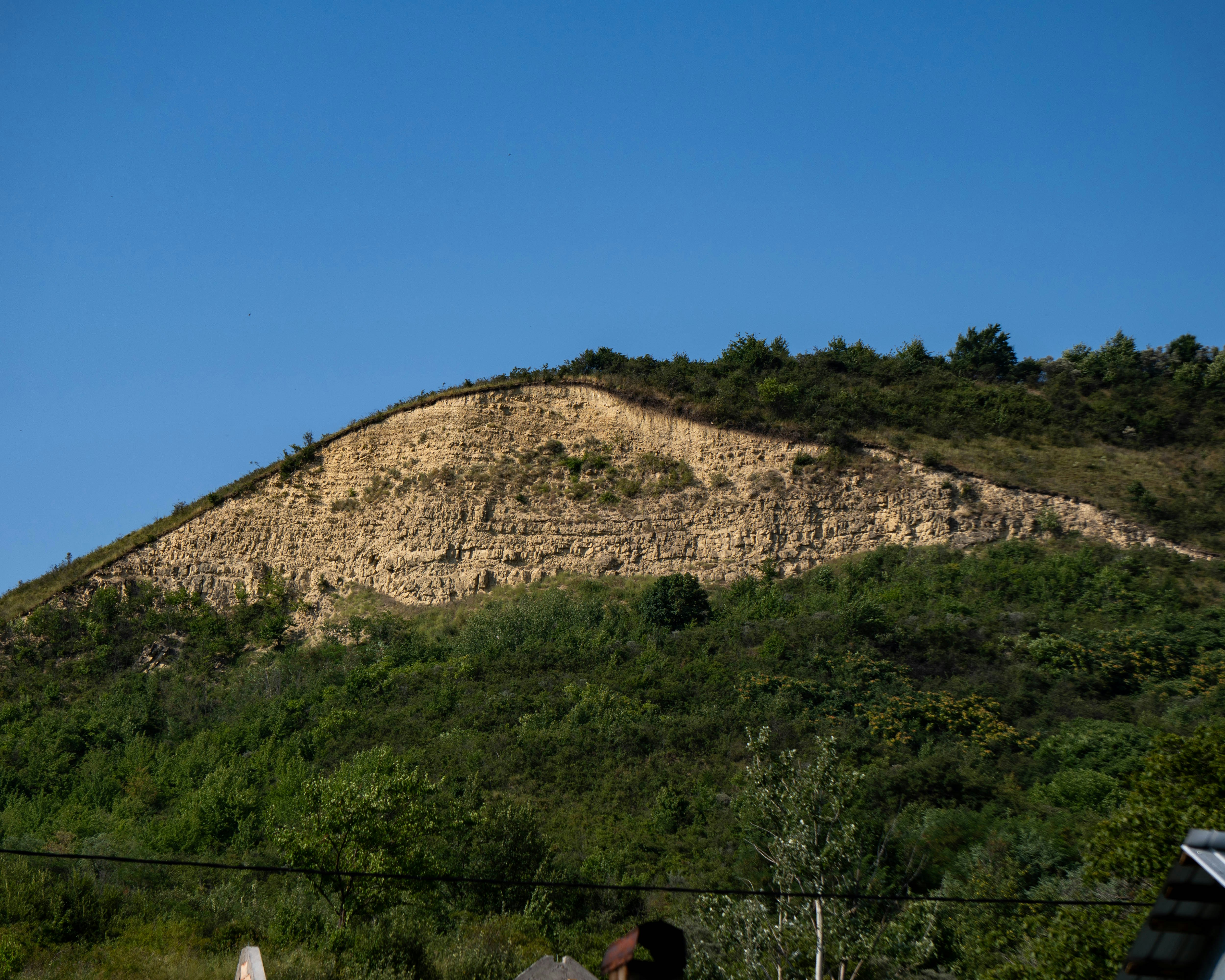Sunlit Quarry Ridge Above Green Crest