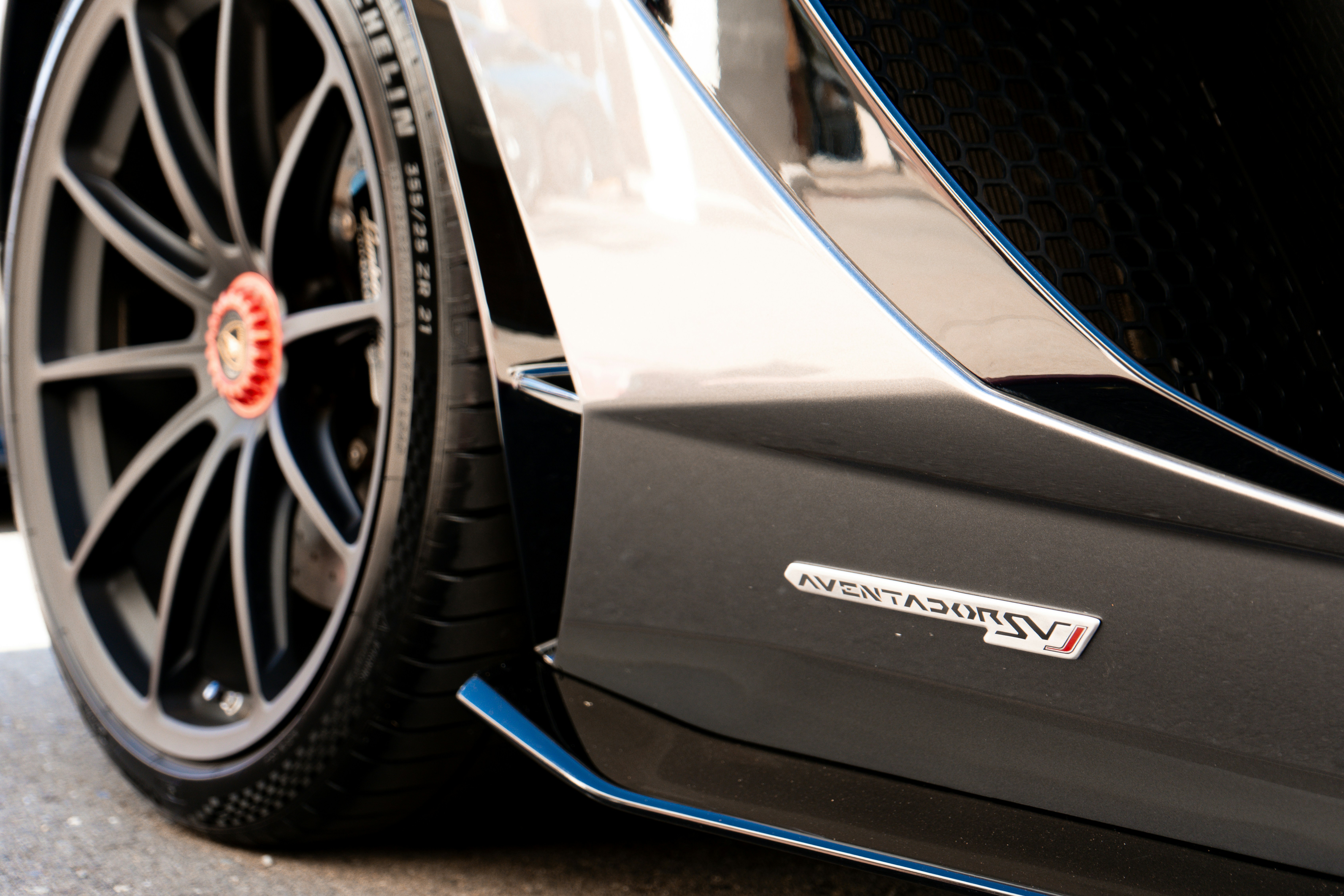Low-angle close on the vented side of a high-performance hybrid showing brand badge and wheel detail