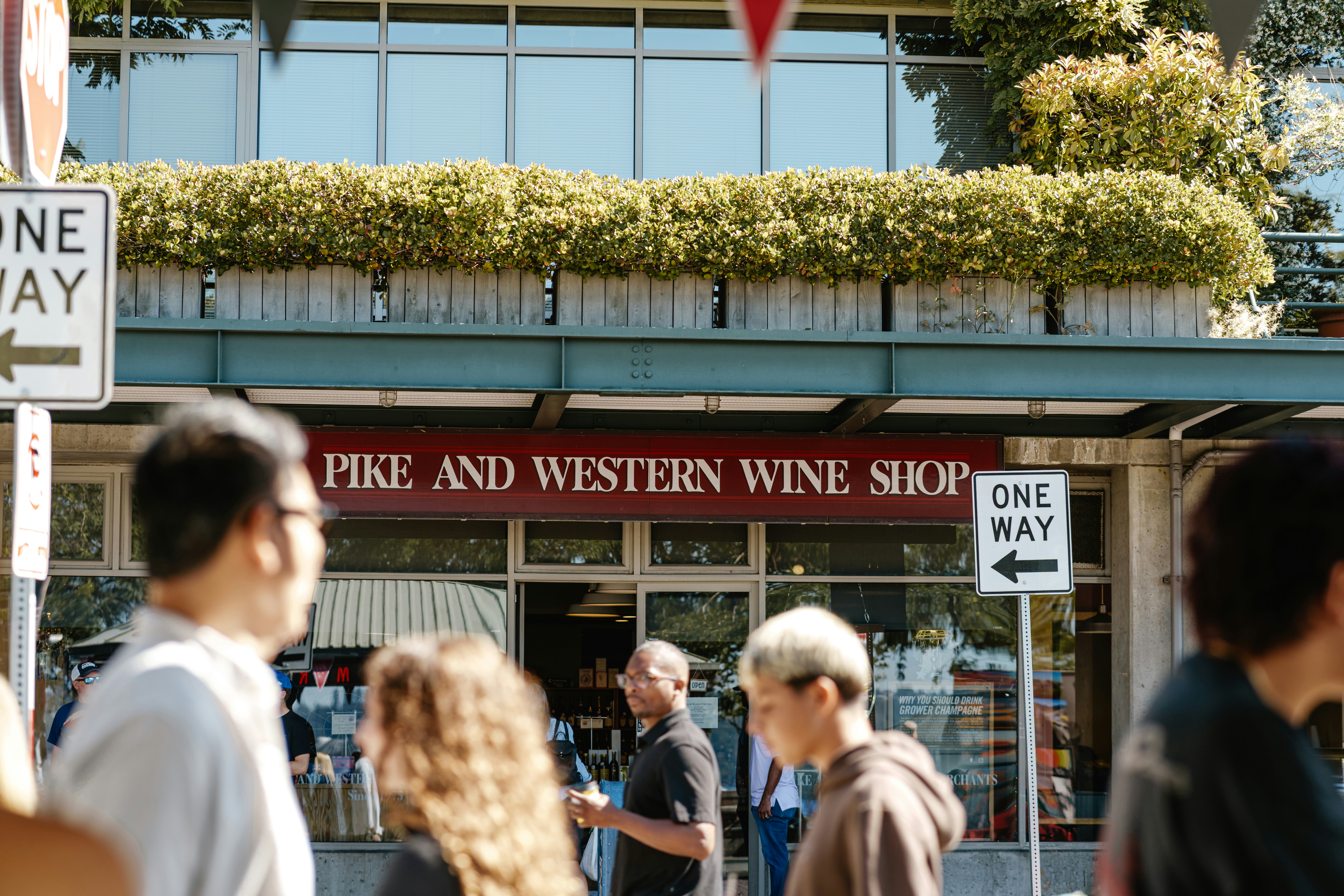 Crowd in Motion Before a Wine Shop under a Green Canopy