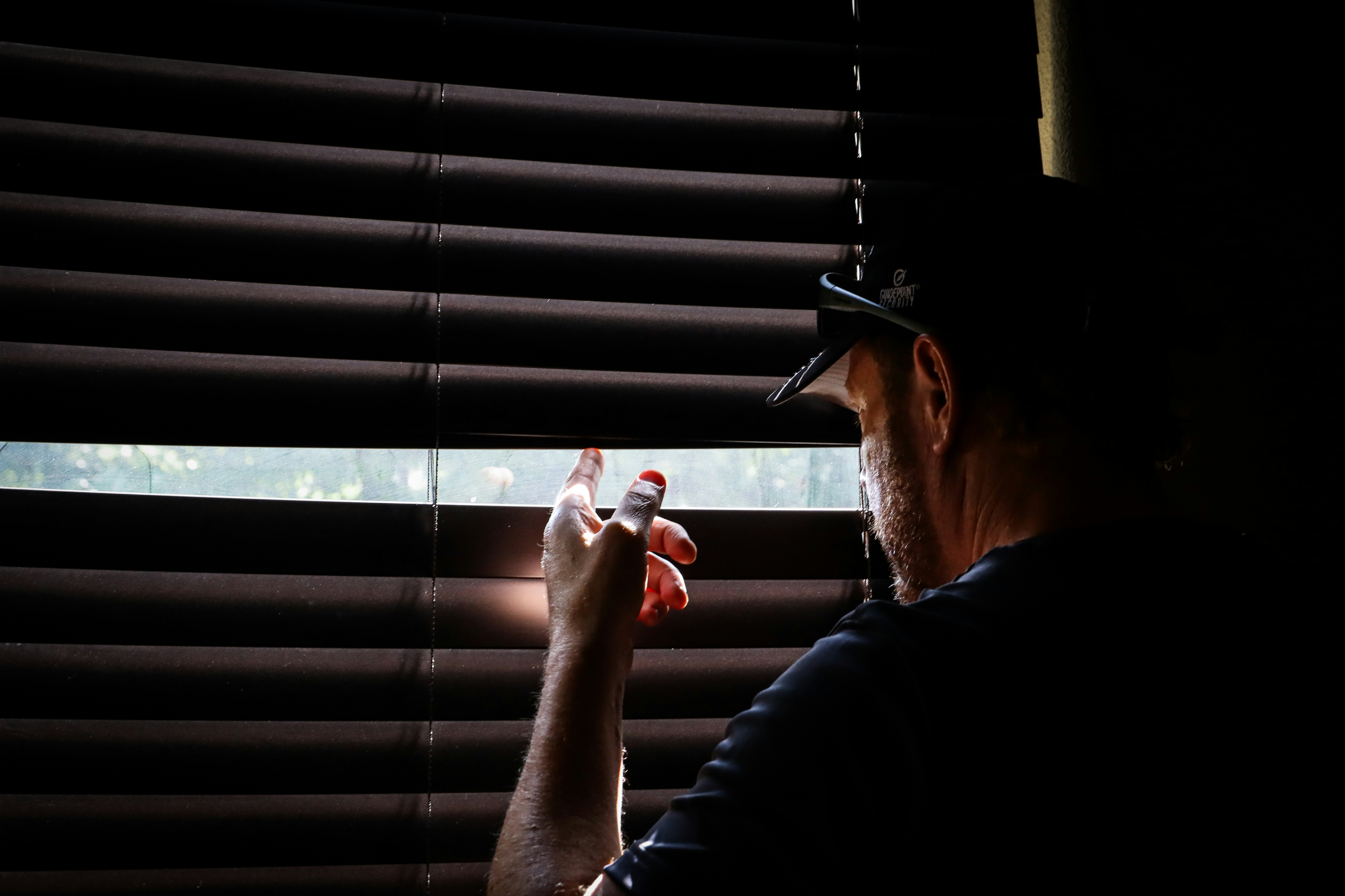 Shadowed Hands and a Glimpse Through Slats