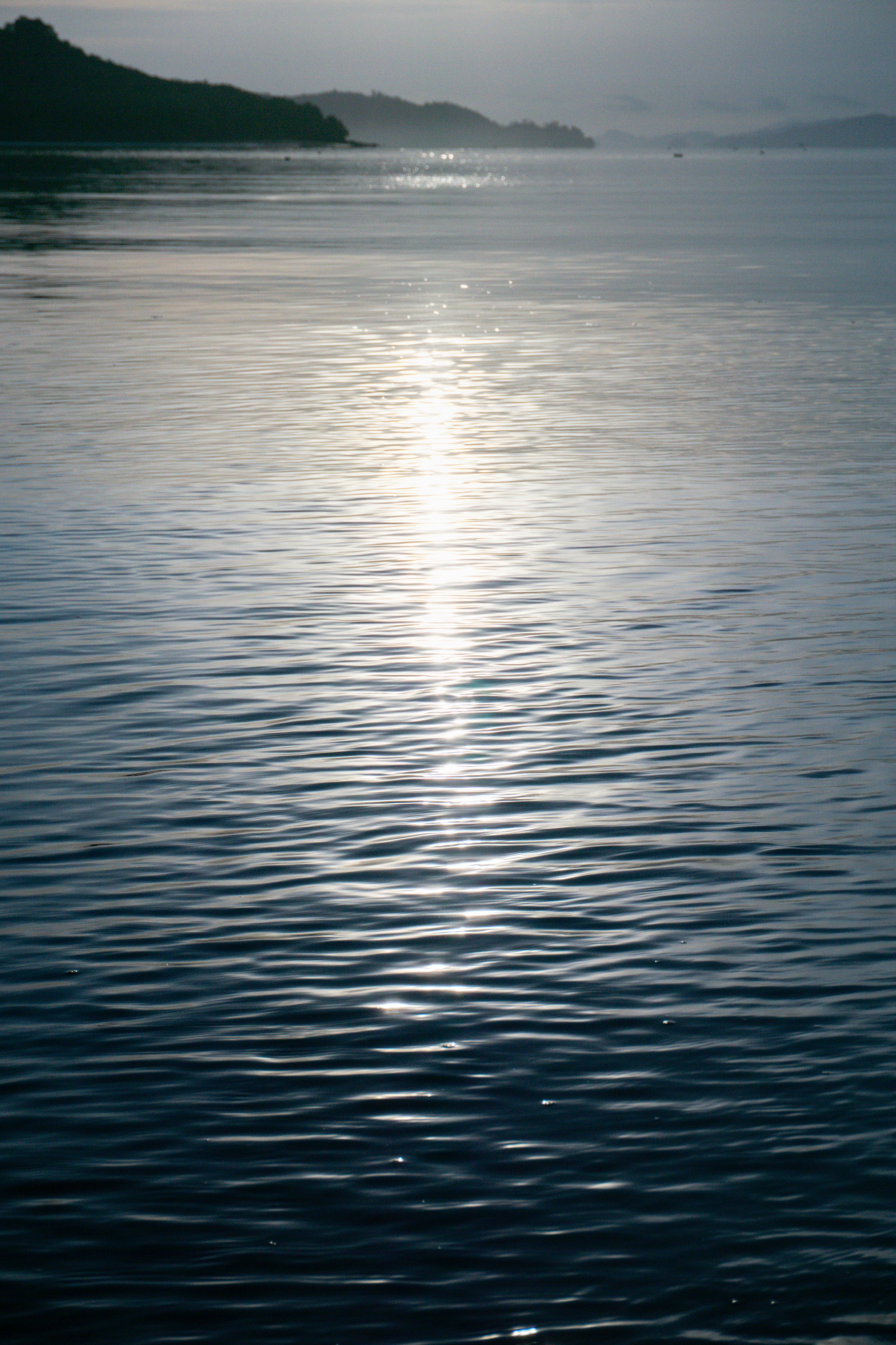 Silvery Ribbon: Sunset Reflections on a Calm Bay