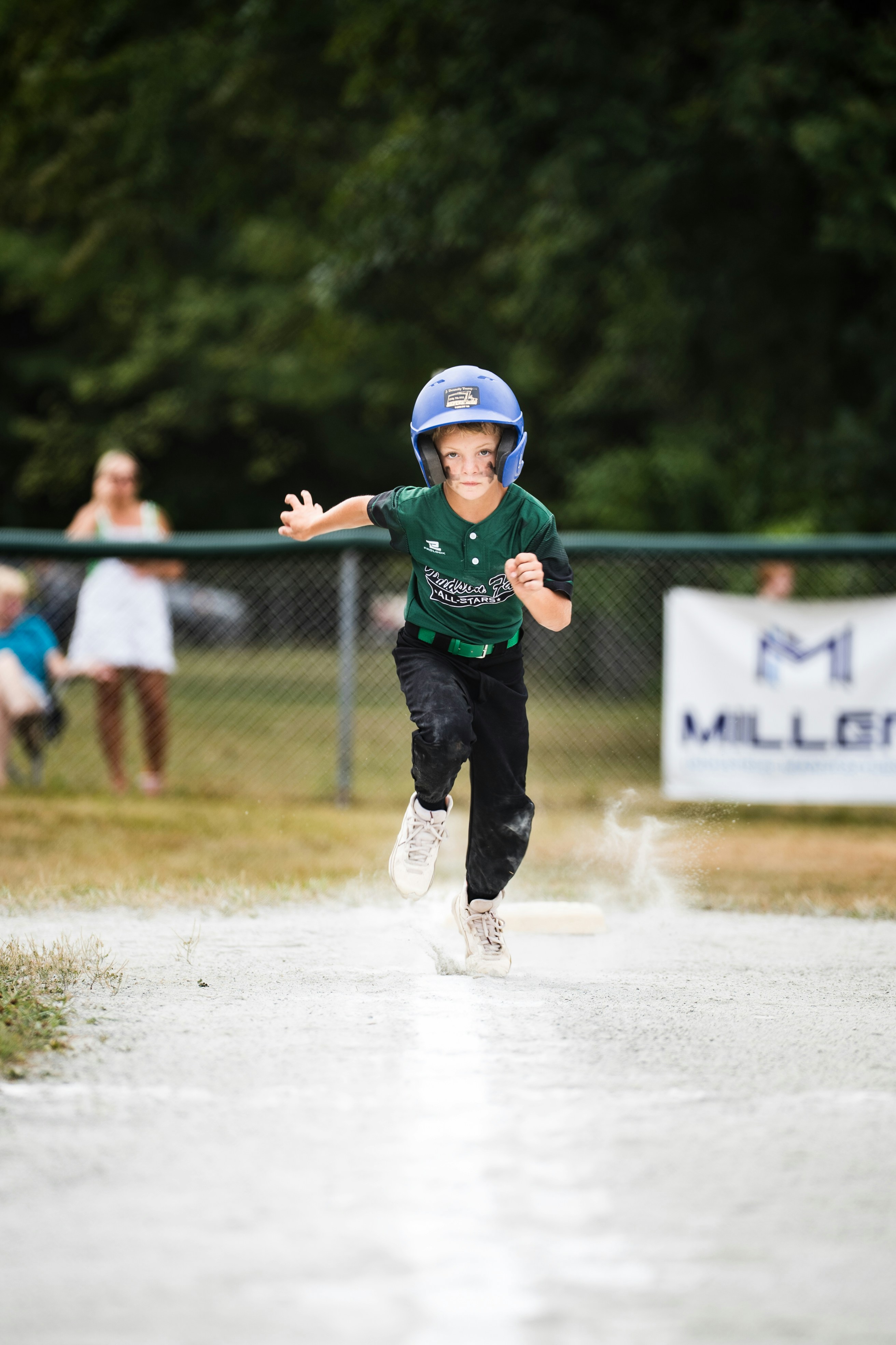 Runner in a Green Jersey Slides into Home on a Rainy Diamond