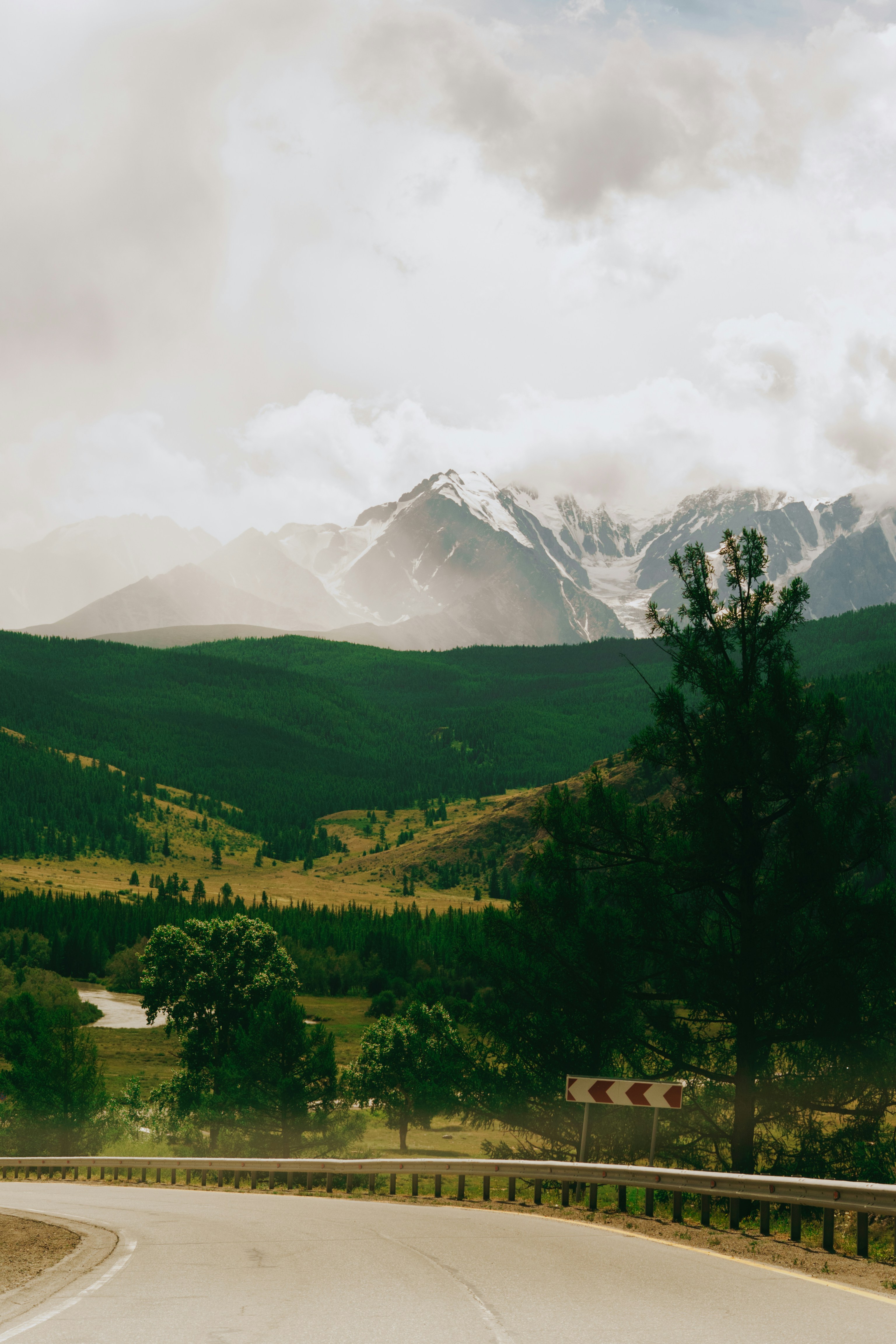 Sunlit Valley Road Toward Snow-kissed Peaks