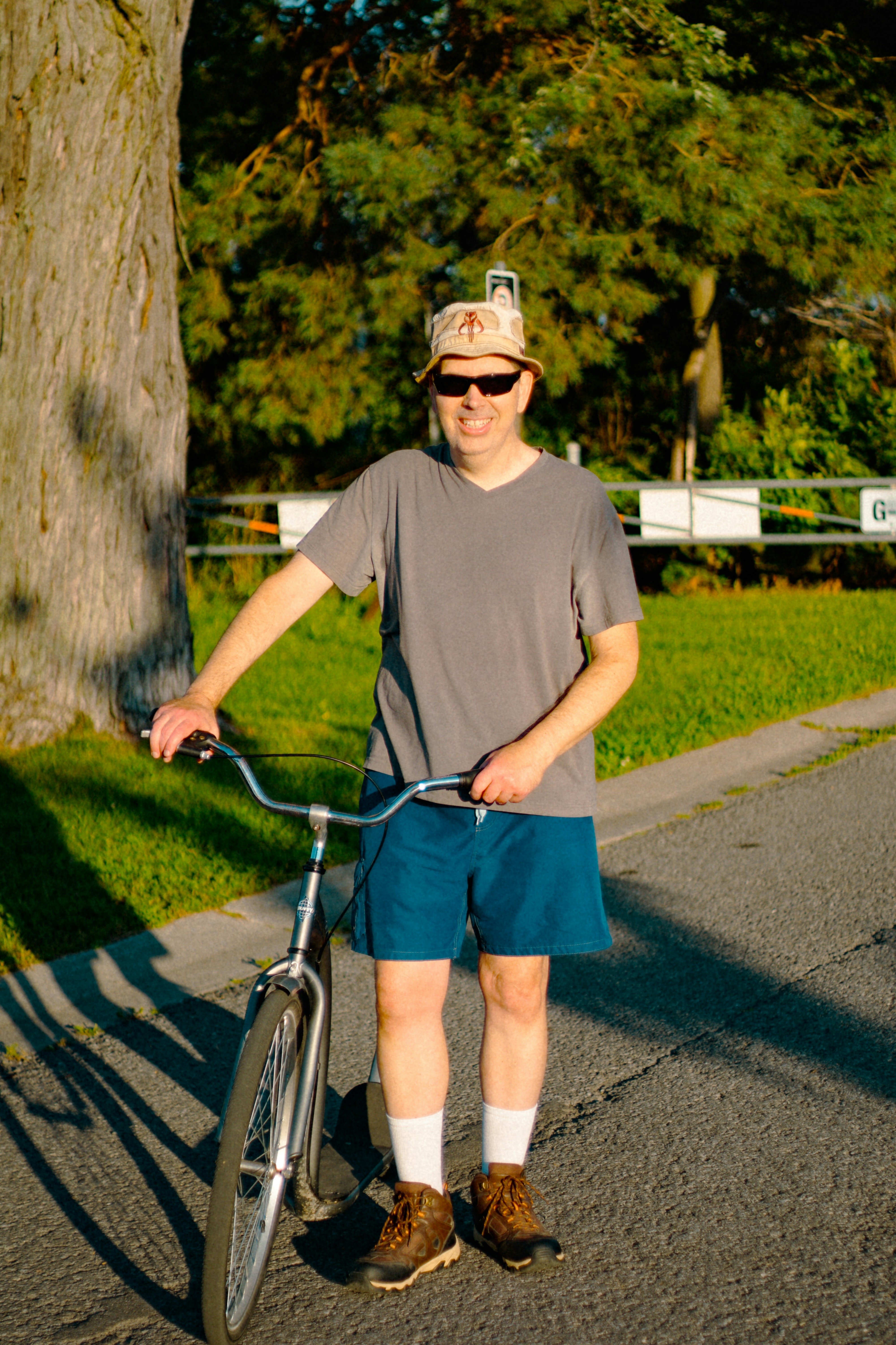 Cyclist on a sunlit park path with a vintage cap and bicycle