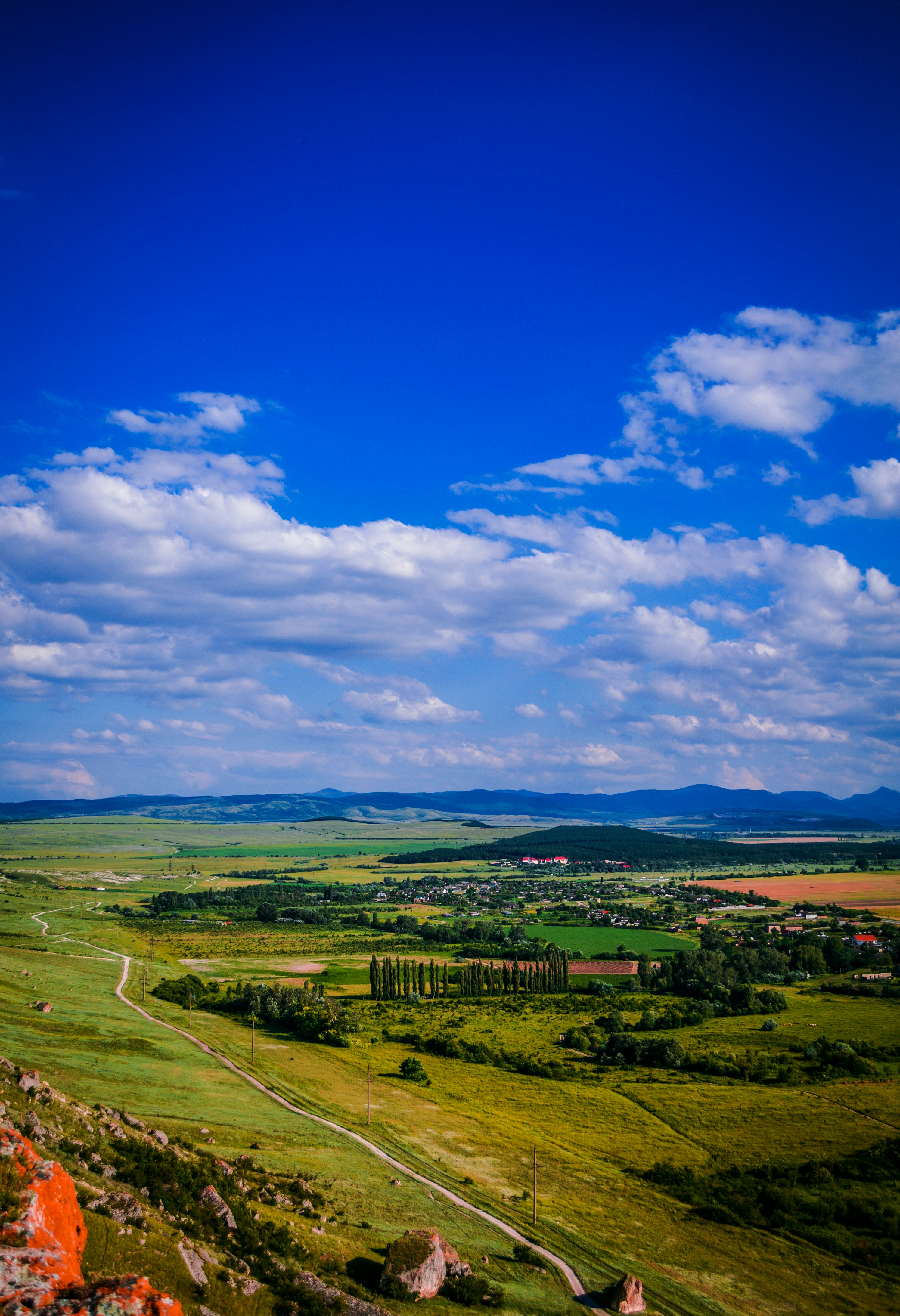 Rolling Green Valleys Under a Wide Blue Sky
