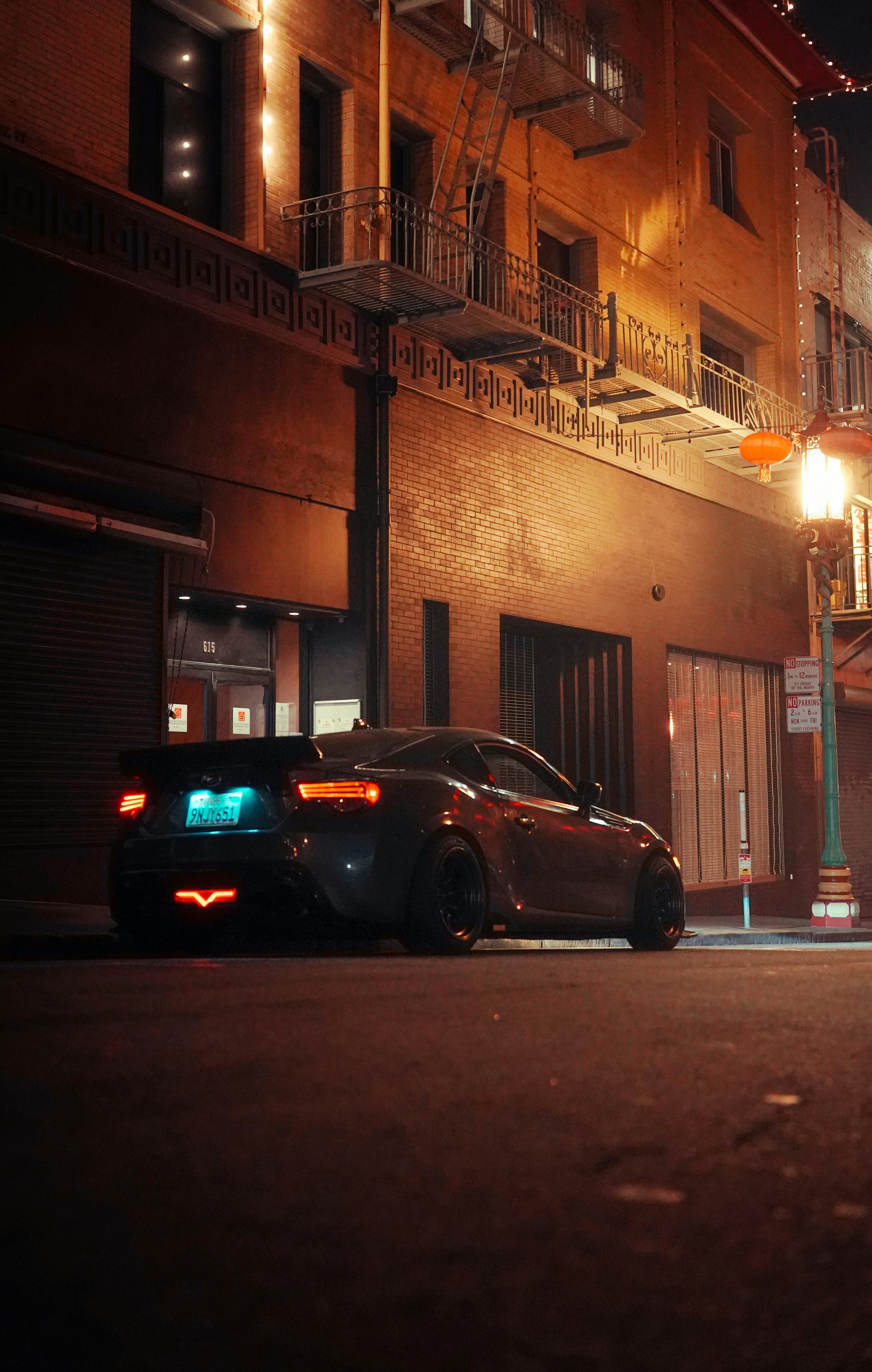 Neon Street Quiet: A Black Car under City Lights