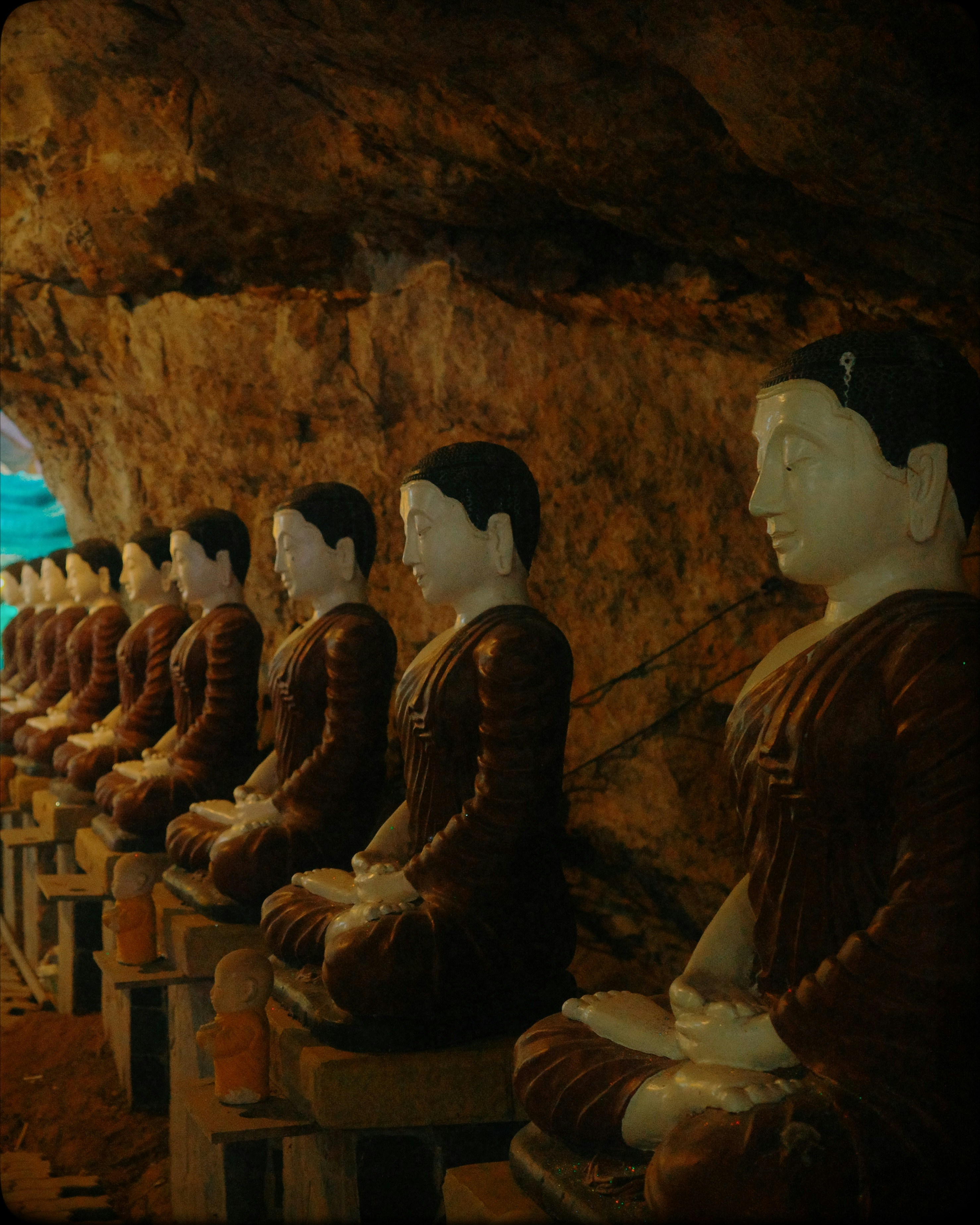 Row of Meditative Buddhas in a Dim Cave