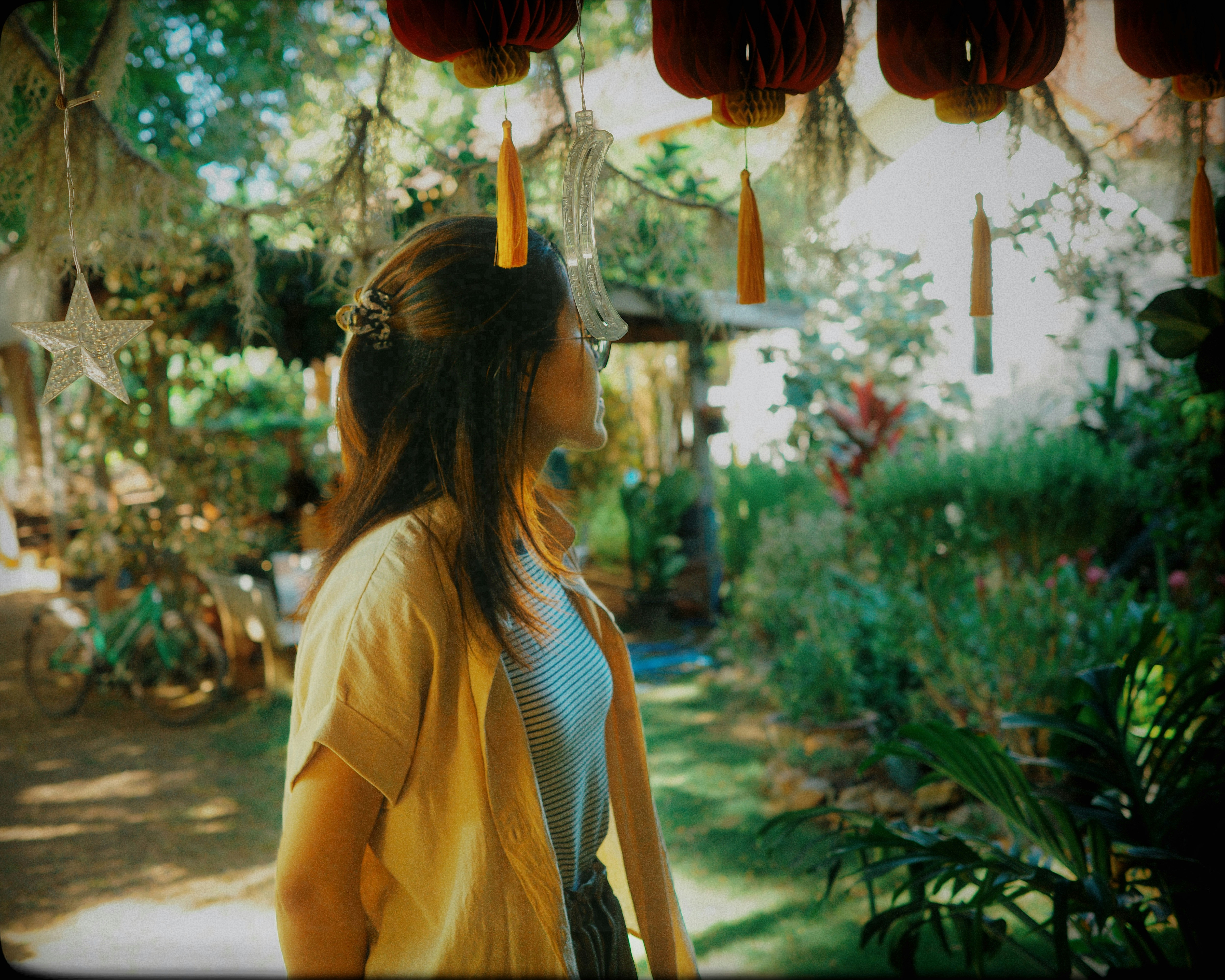 Sunlit Portrait Amid Lanterns and Greenery