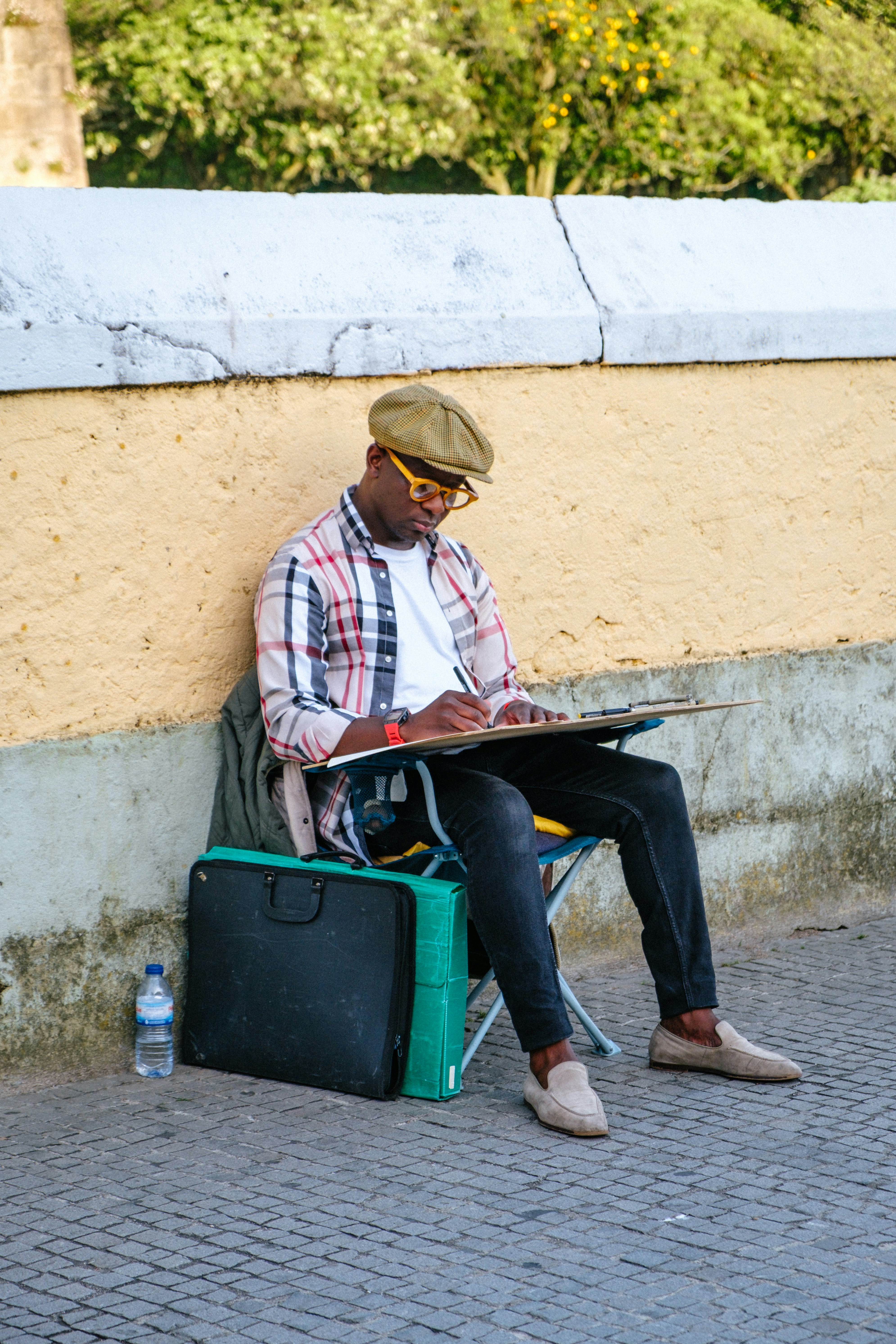 Sketchpad on the Street: A Portrait of Focus under a Sunlit Wall