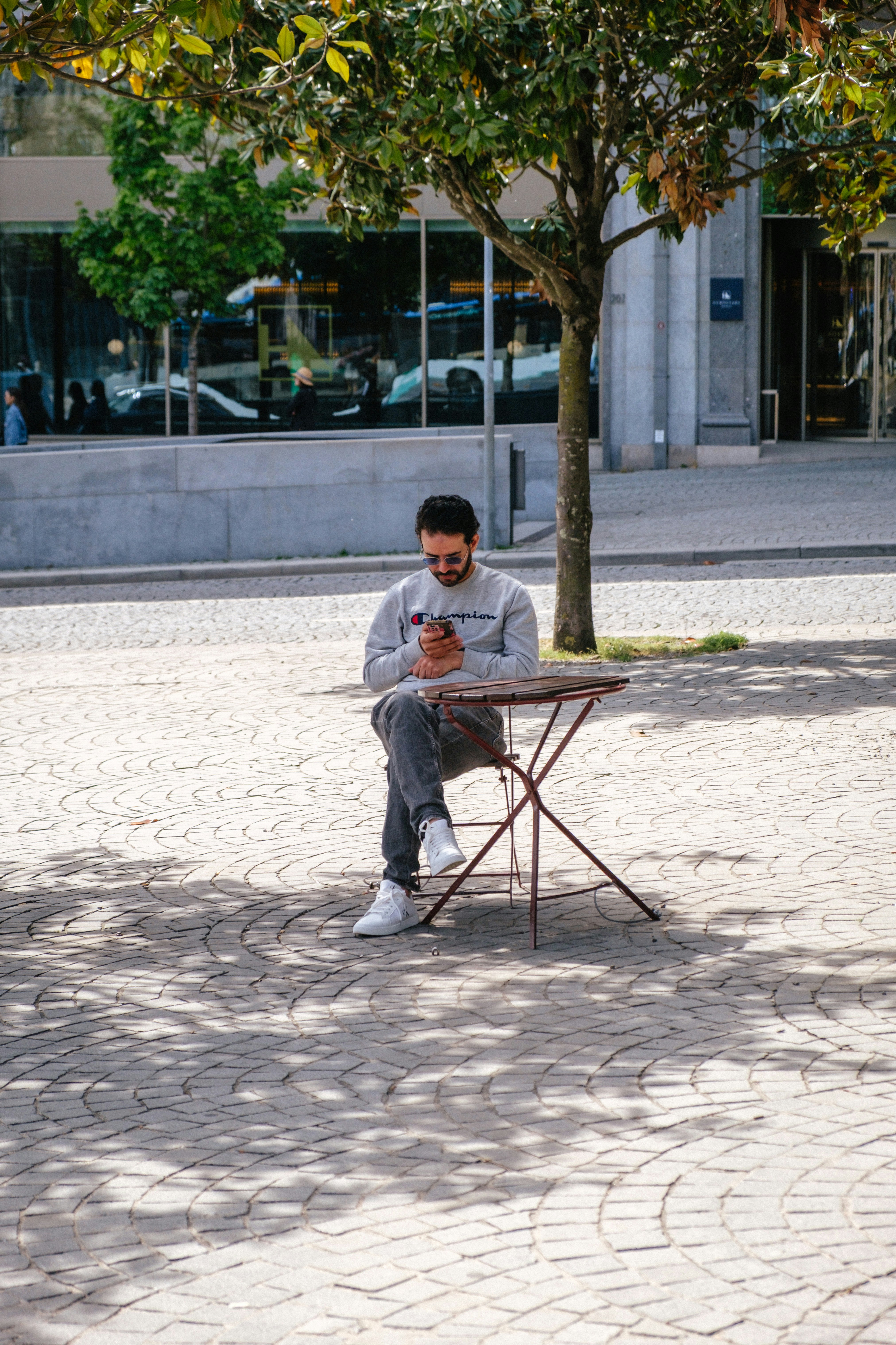 A Quiet Moment: a Street Illustrator Breaks for a Message on Glassy Pedestal