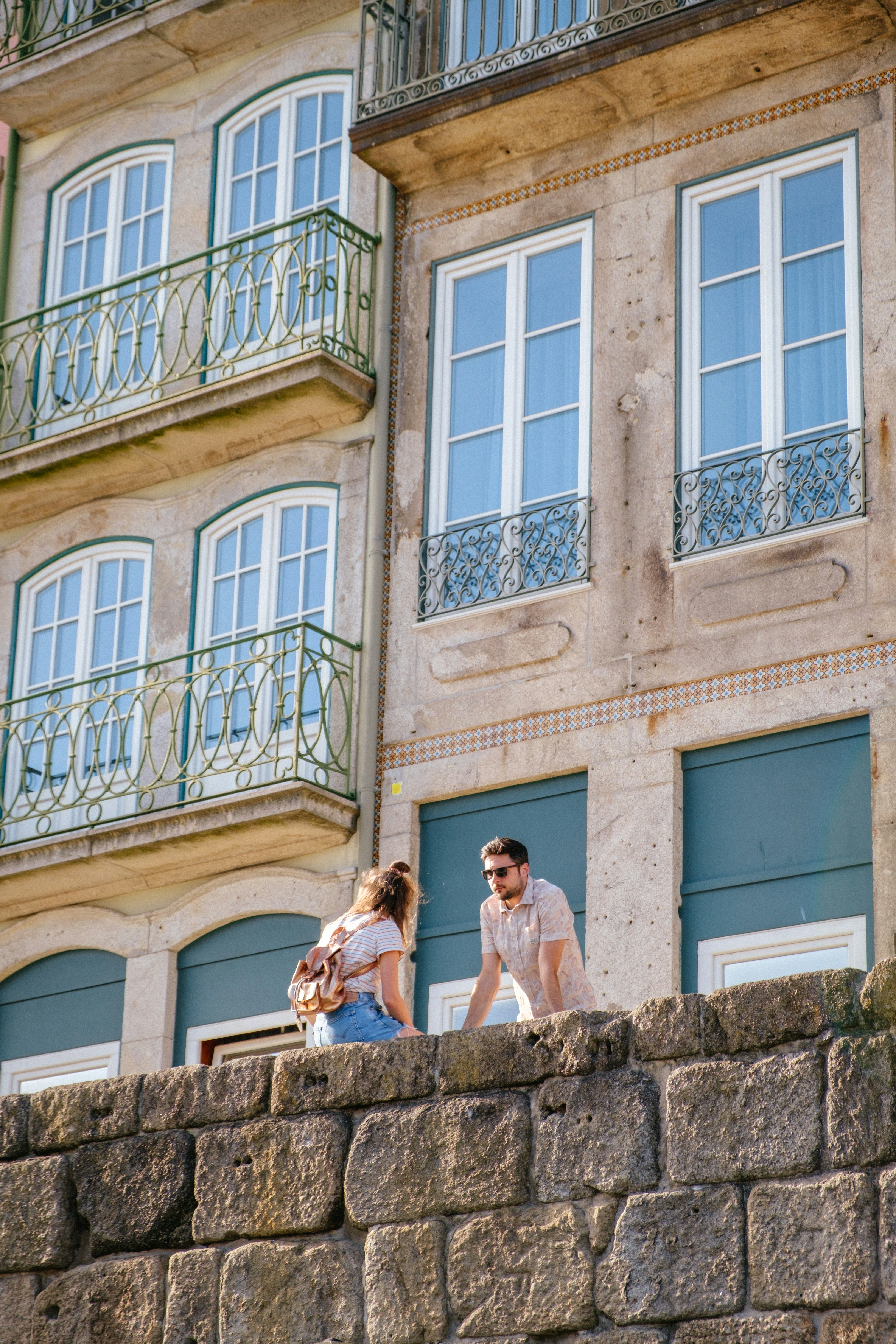 Two Friends on a Historic Terrace Under European Facades