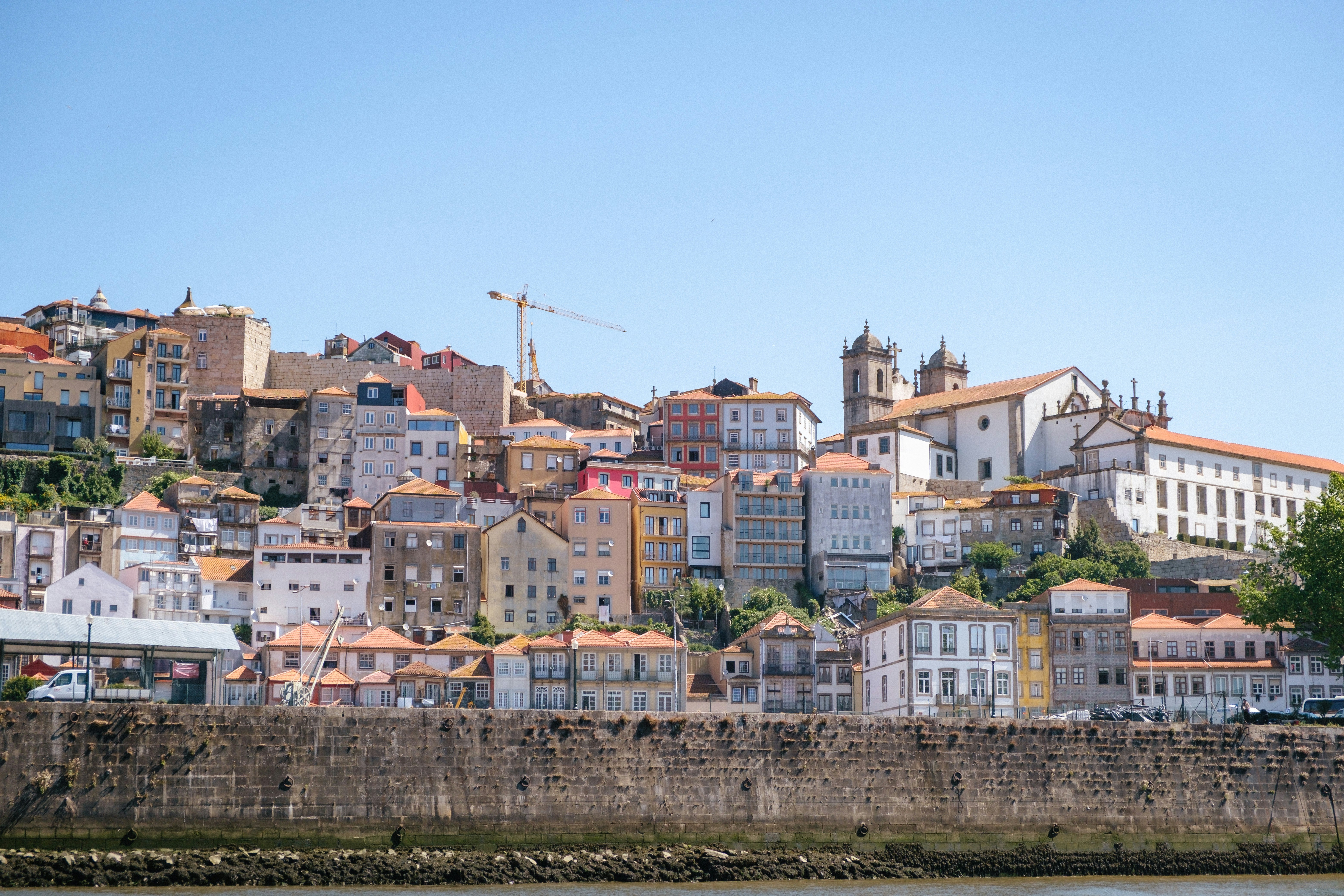 Colorful hillside harbor: sunlit row of townhouses under clear blue sky