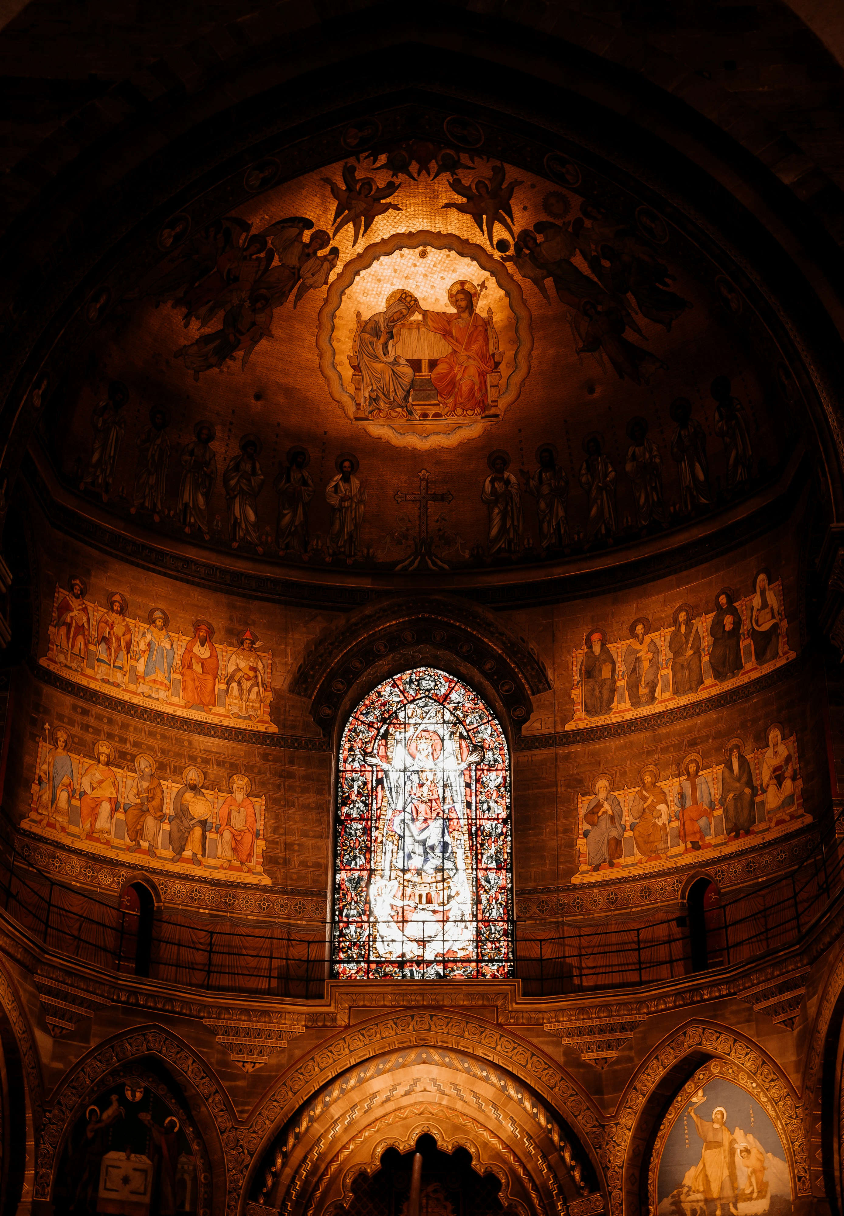 Glowing Mosaic: Stained Glass and Sacred Artwork Illuminated in a Dim Cathedral
