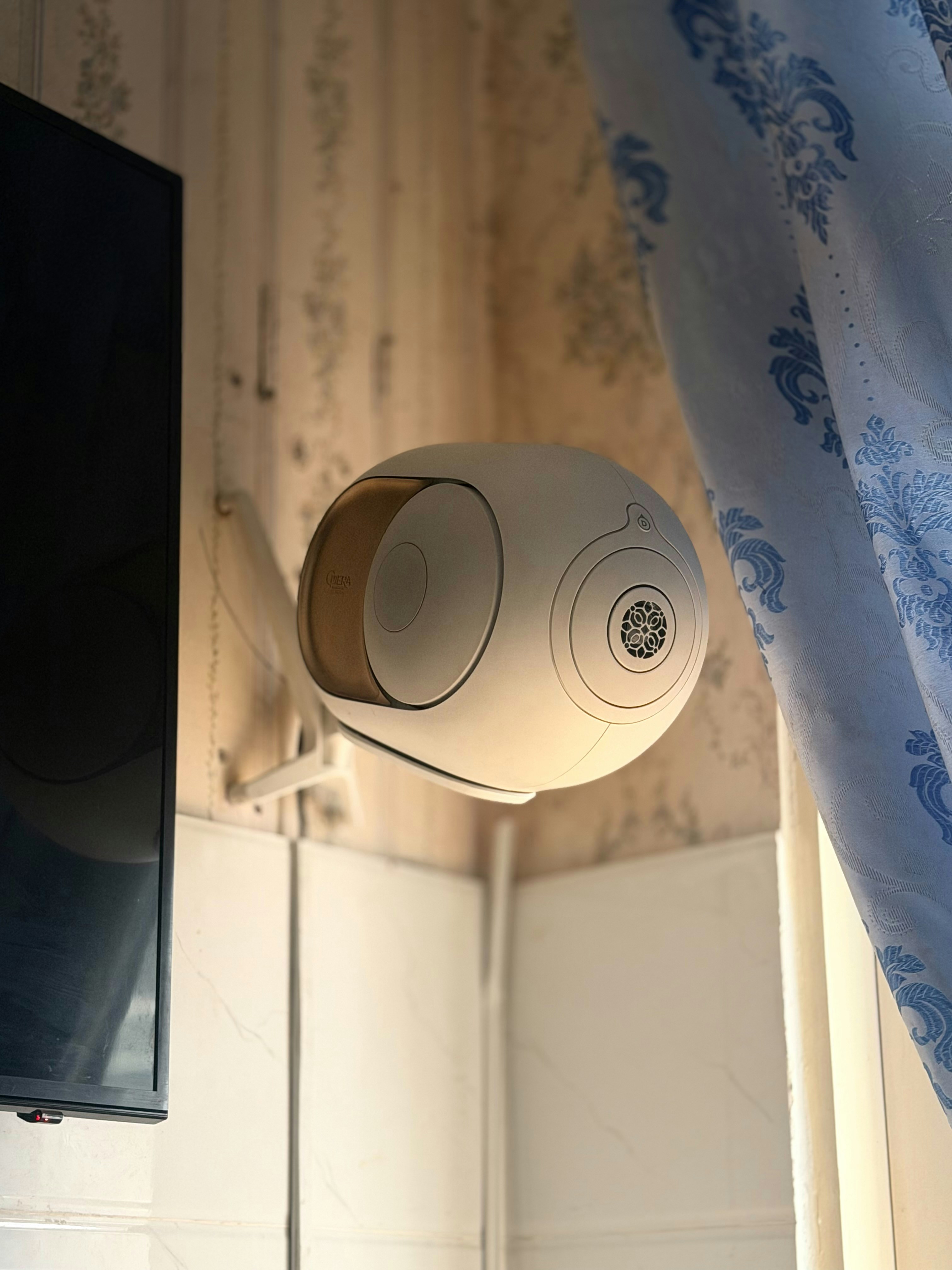 Rounded camera hub suspended beside a side-lit screen