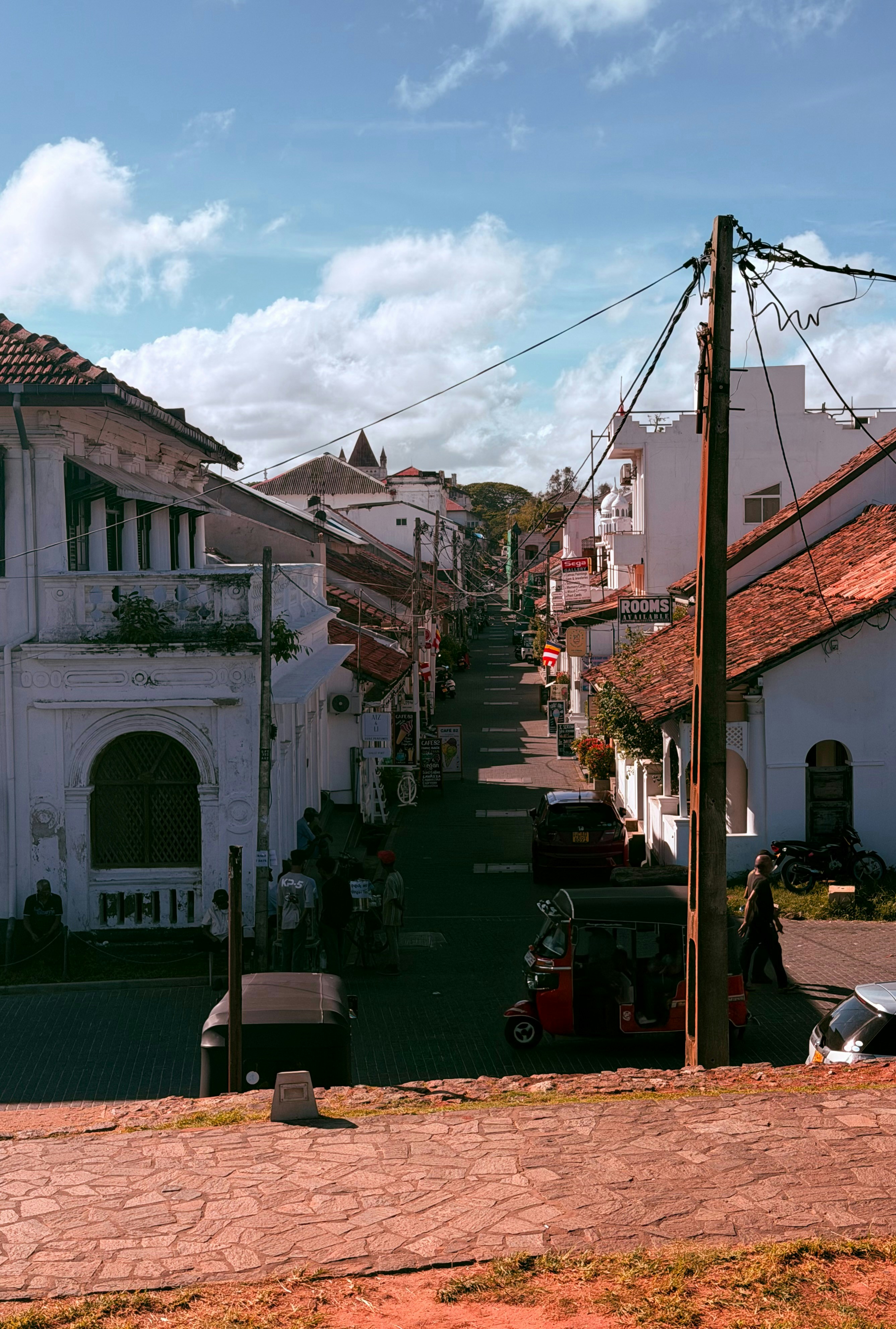 Sunlit Alleyway: A Colonial Street Bounded by White Facades