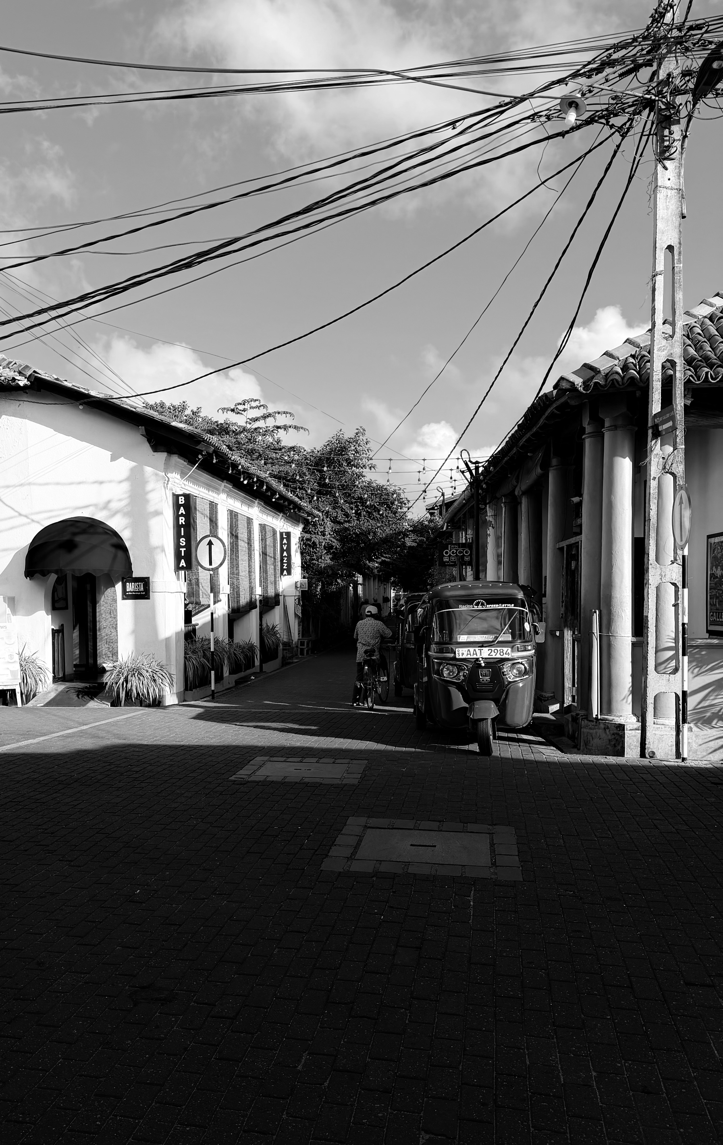 Sunlit Street Corridor: Vehicle, Pedestrians, and Wires