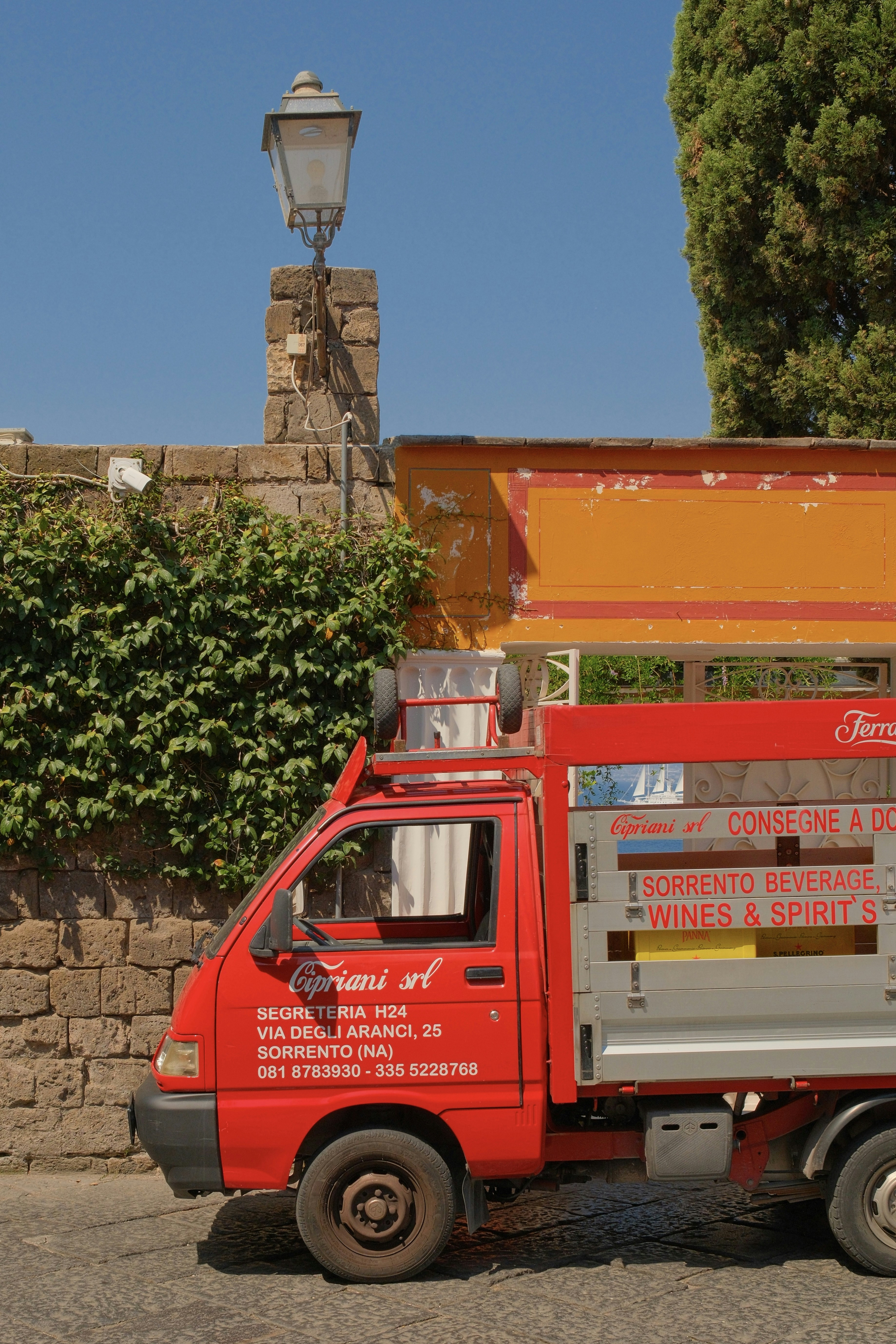 Red Delivery Truck in Sunlit Italian Street