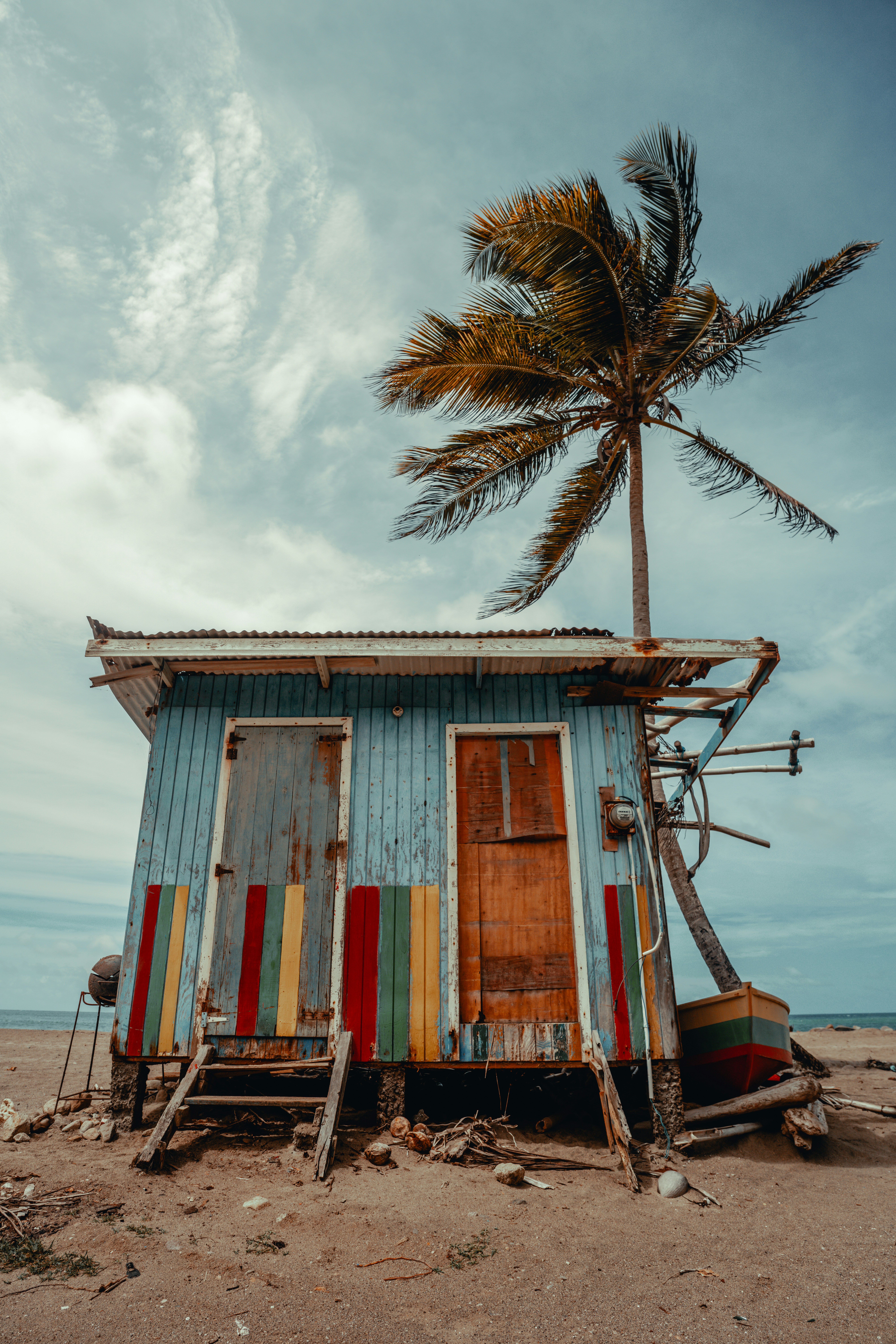 Color-Battered Beach Shack Under a Leaning Palm