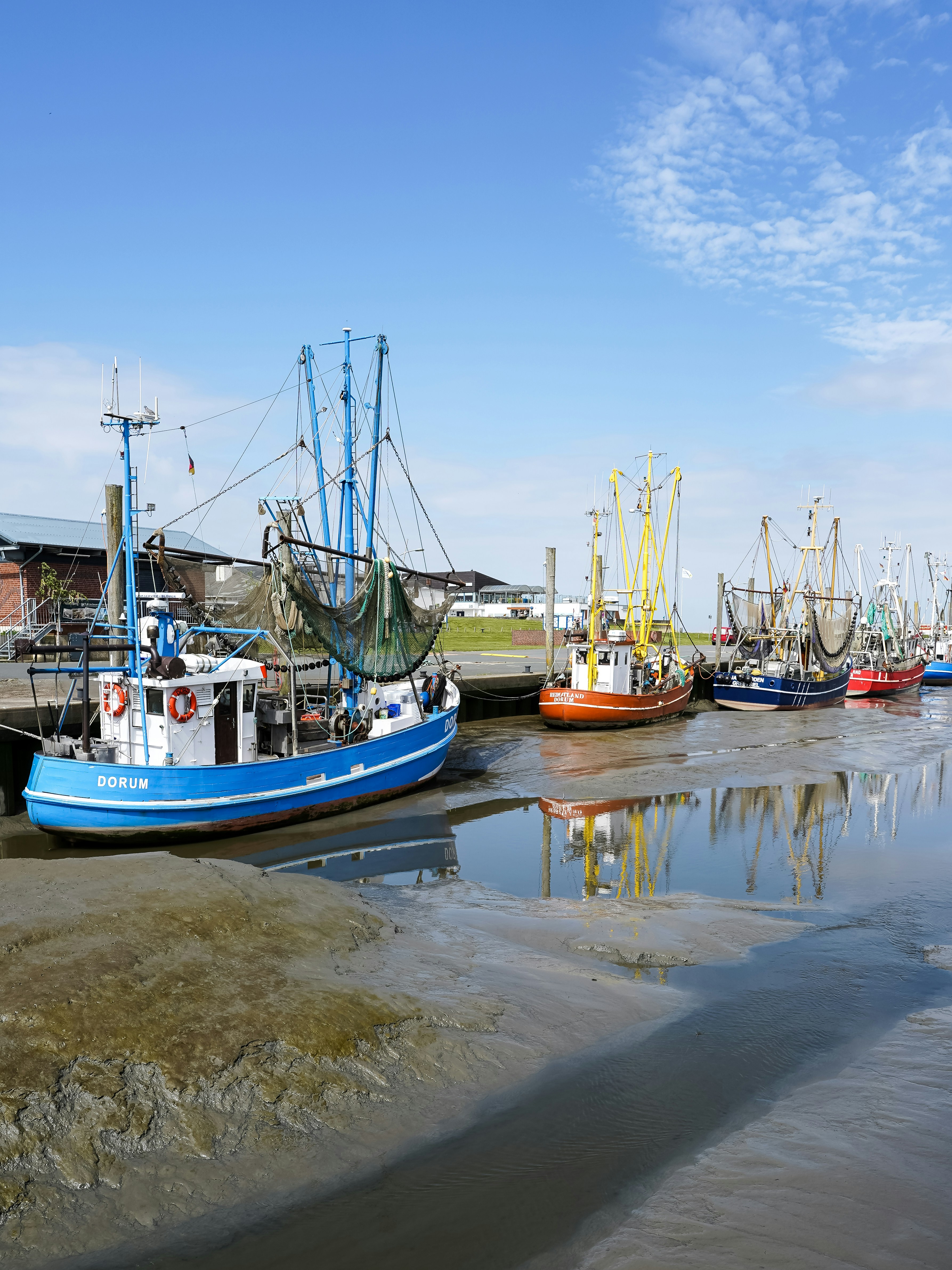 Vibrant Fleet at Low Tide: A Quiet Channel of Colorful Boats