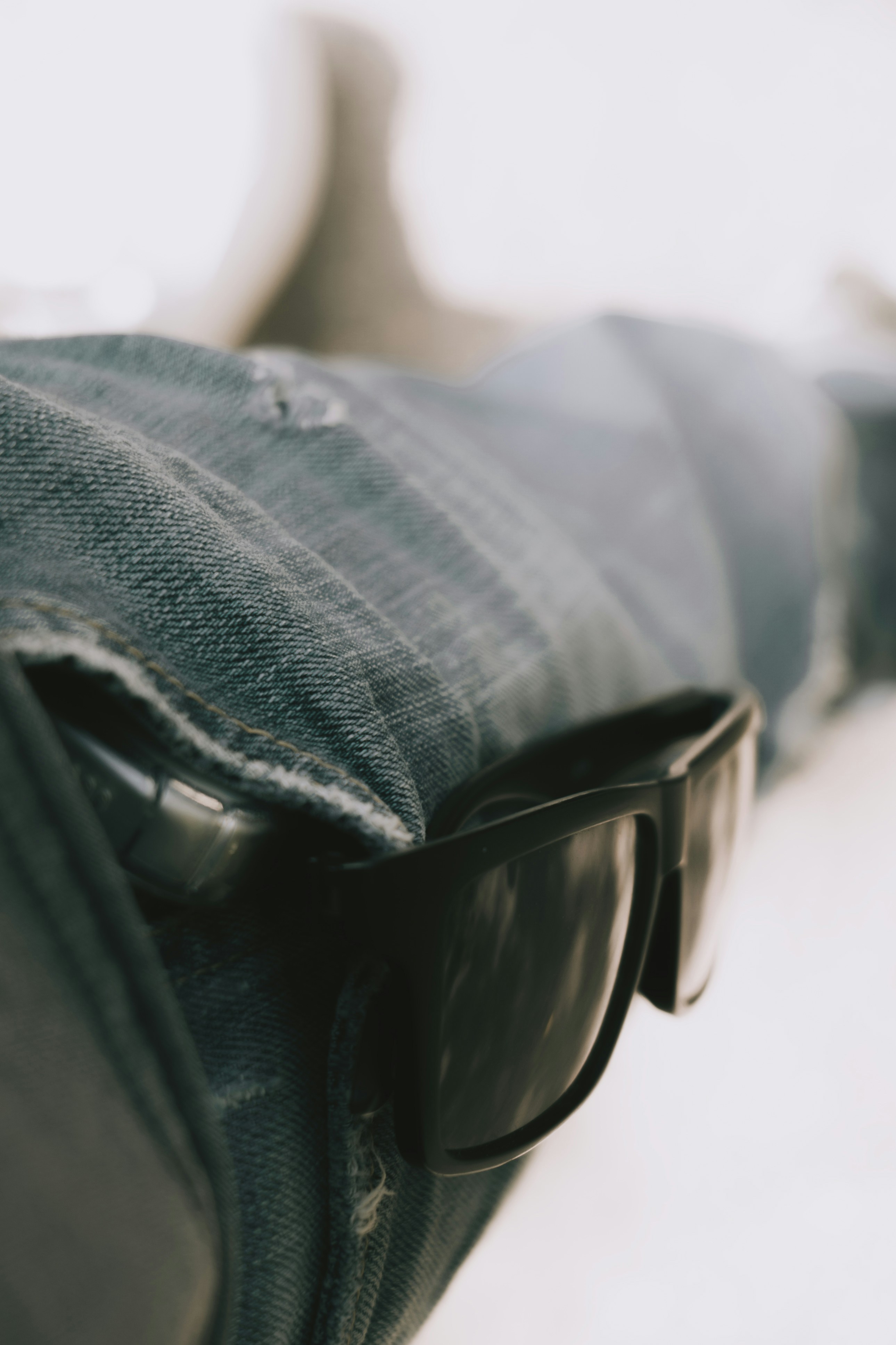 Close-Up of Sunglasses Slung Over Denim on a Casual Day