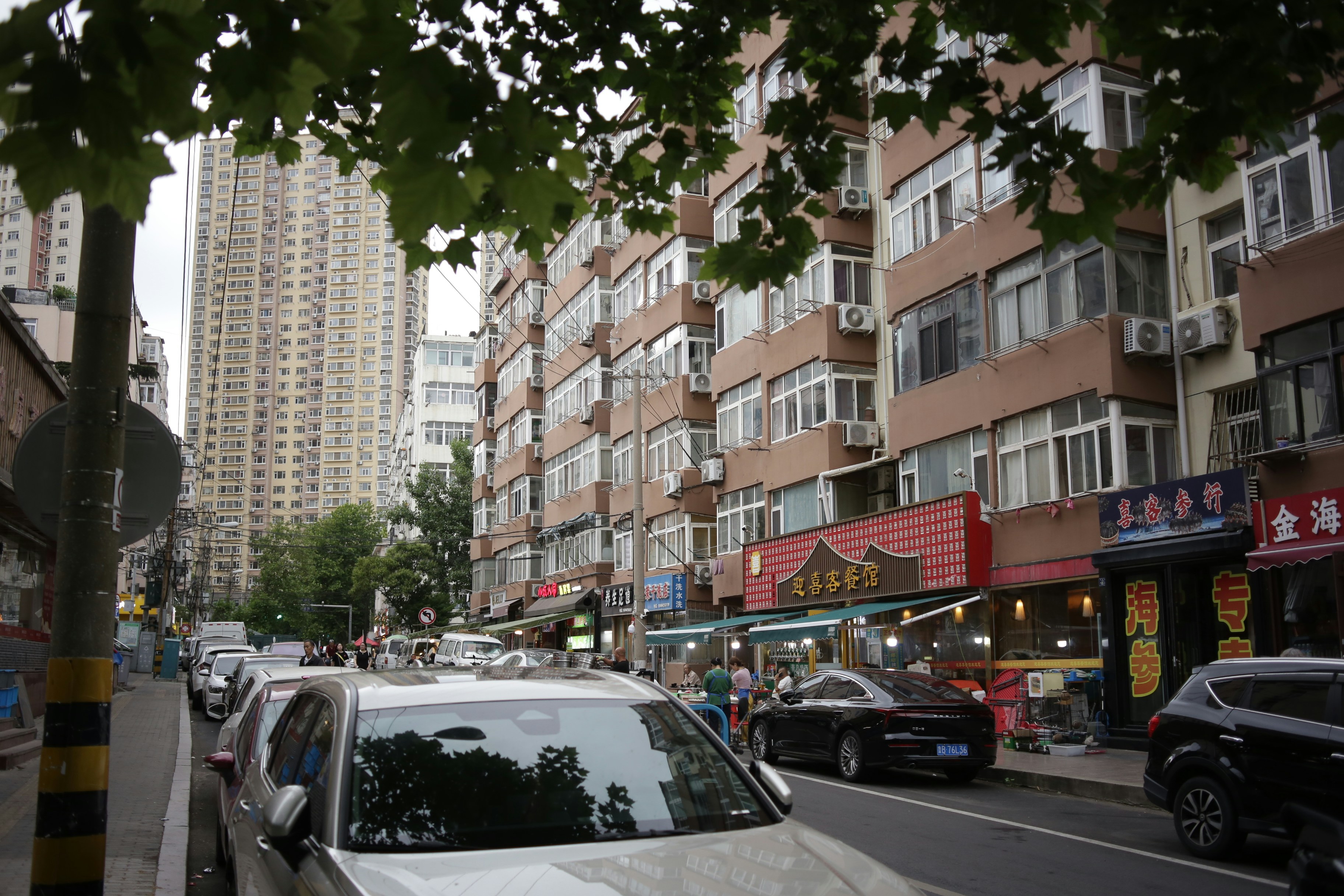 Street Level Pulse: Cars, Signs, and Apartment Facades in a Busy Urban Corridor